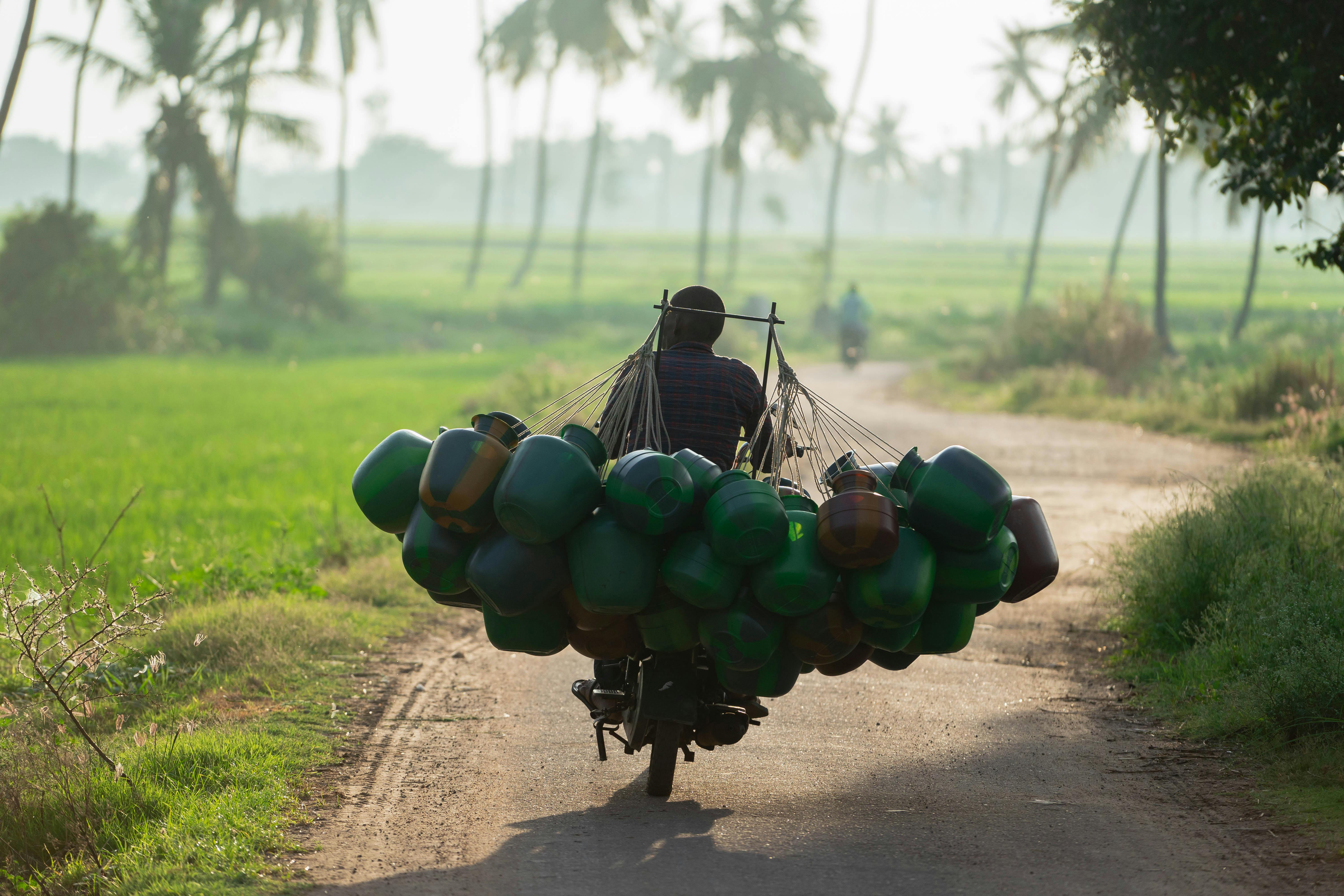 Man Riding Motorbike with Buckets on Dirt Road in Countryside · Free ...