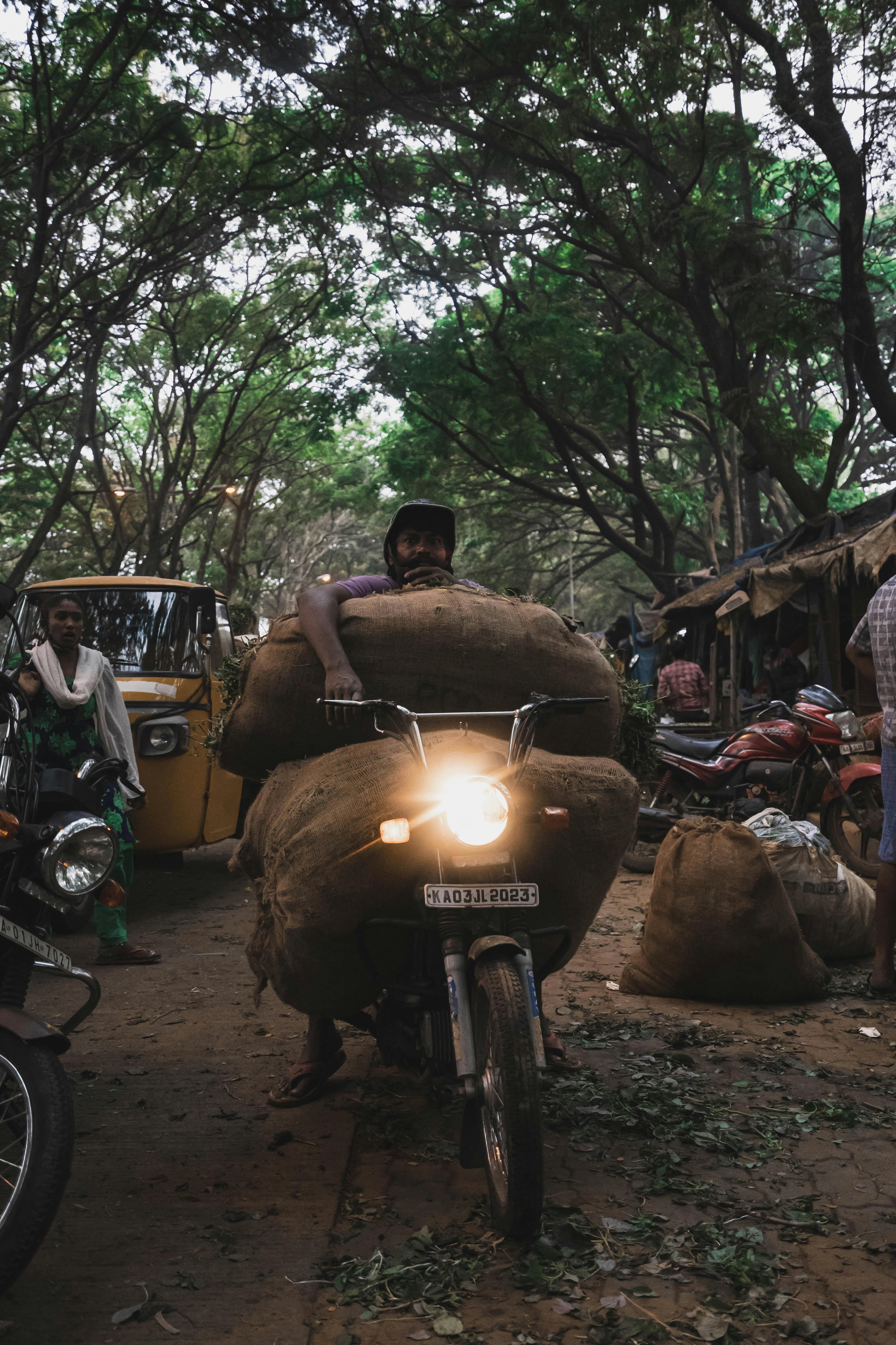 Man Riding Motorbike with Bags in Village · Free Stock Photo