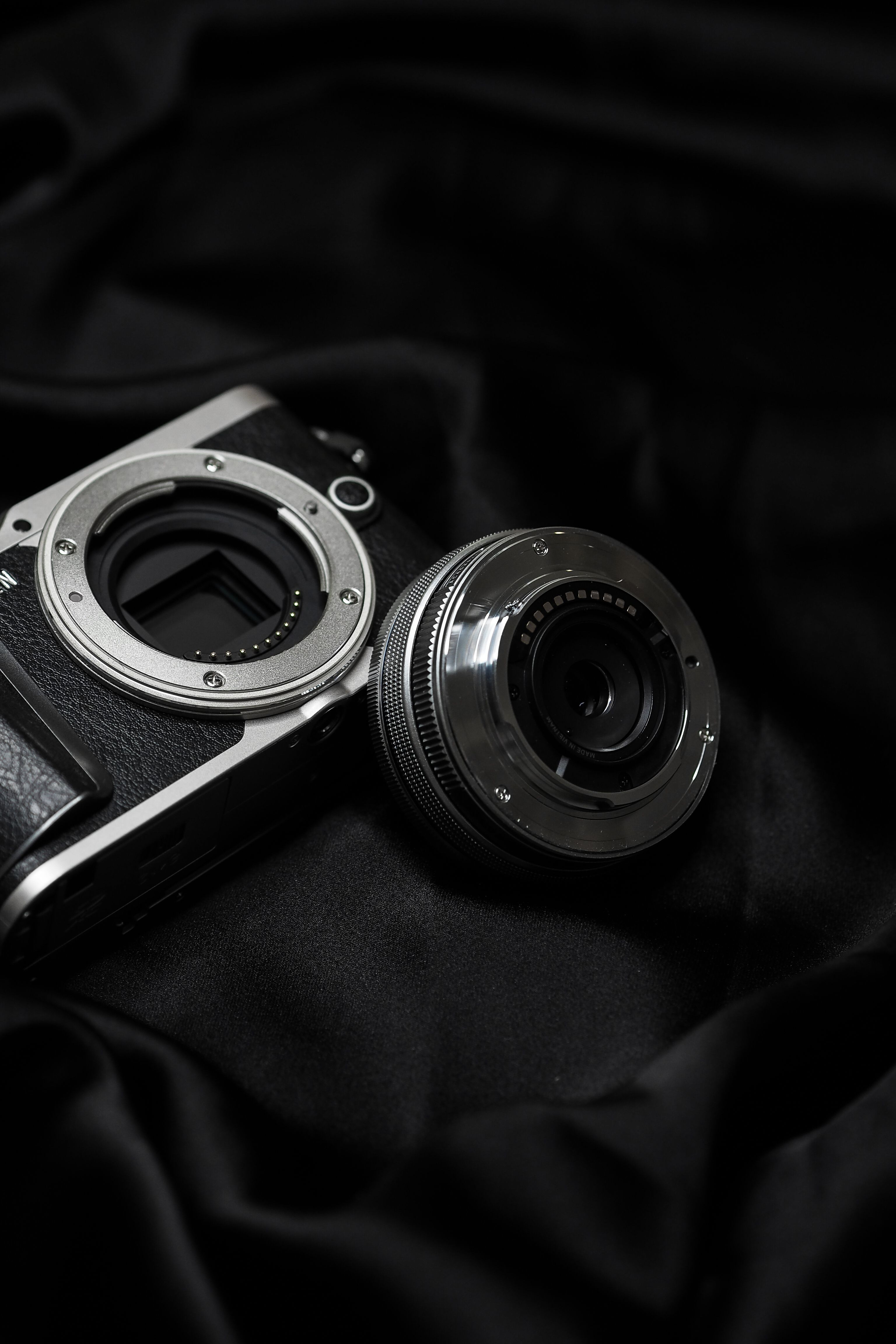 A camera with a lens on top of a black cloth · Free Stock Photo
