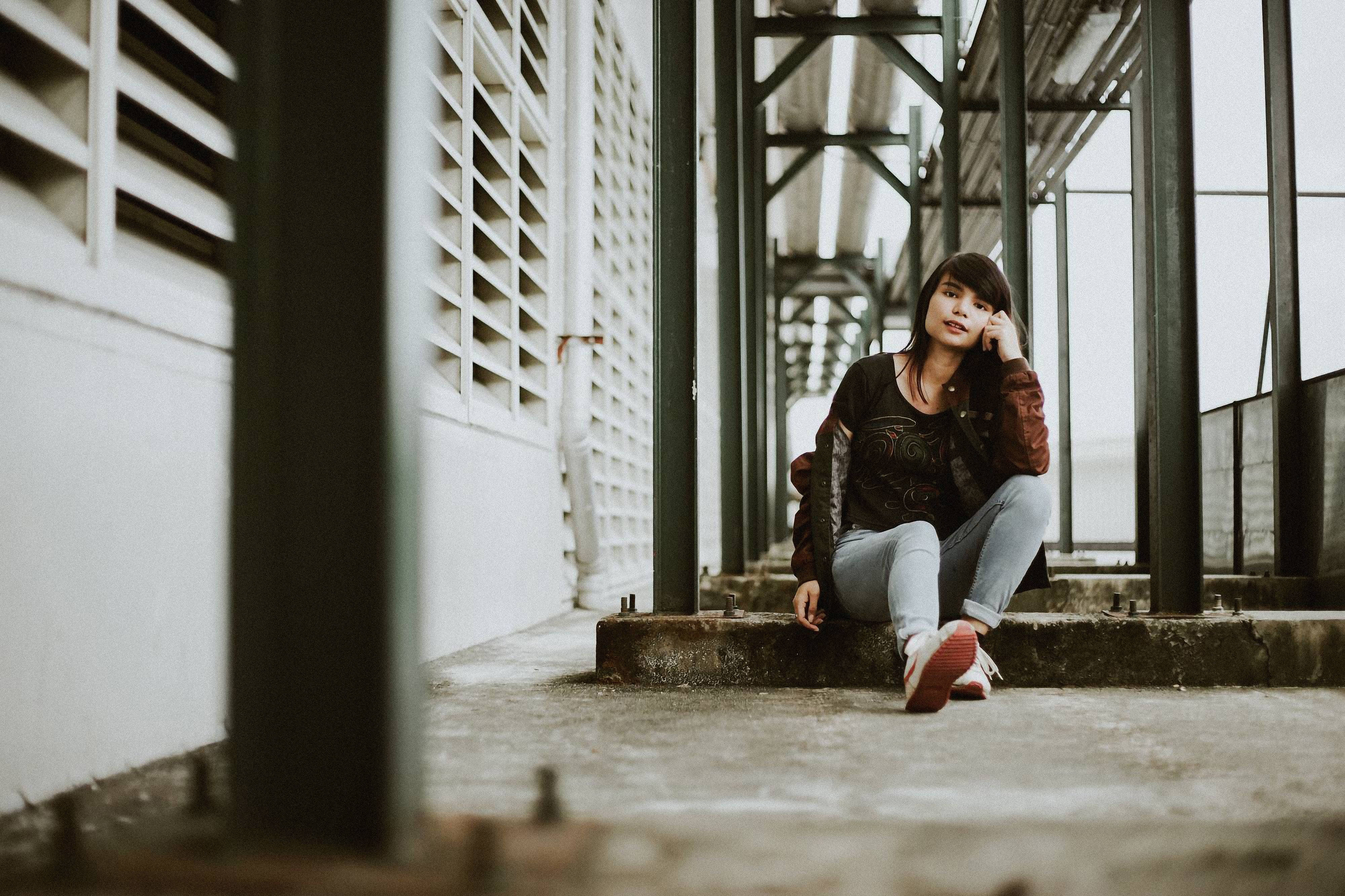 A Young Woman Sitting on a Step by the Building · Free Stock Photo