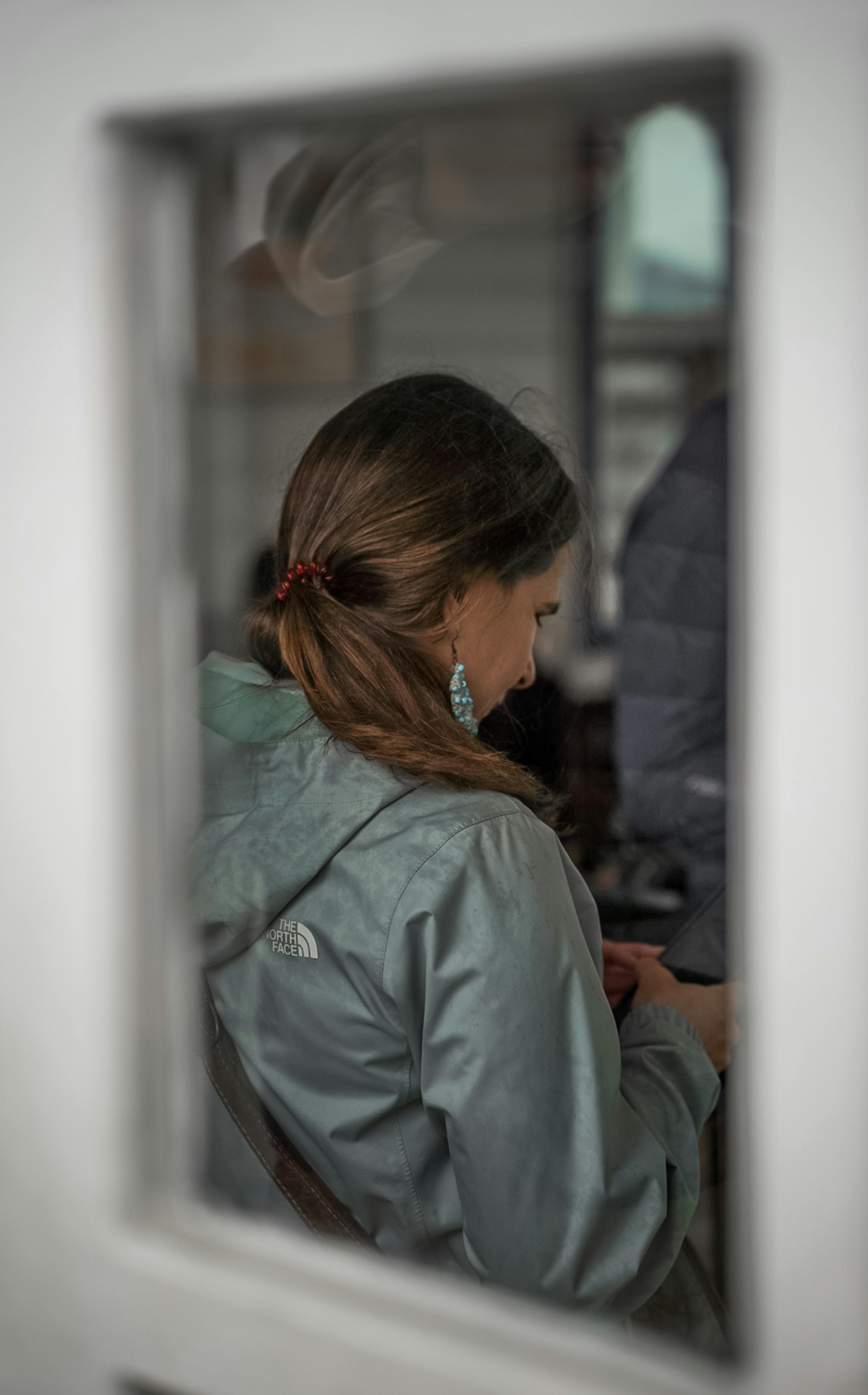 Back View of Woman in Jacket behind Window · Free Stock Photo