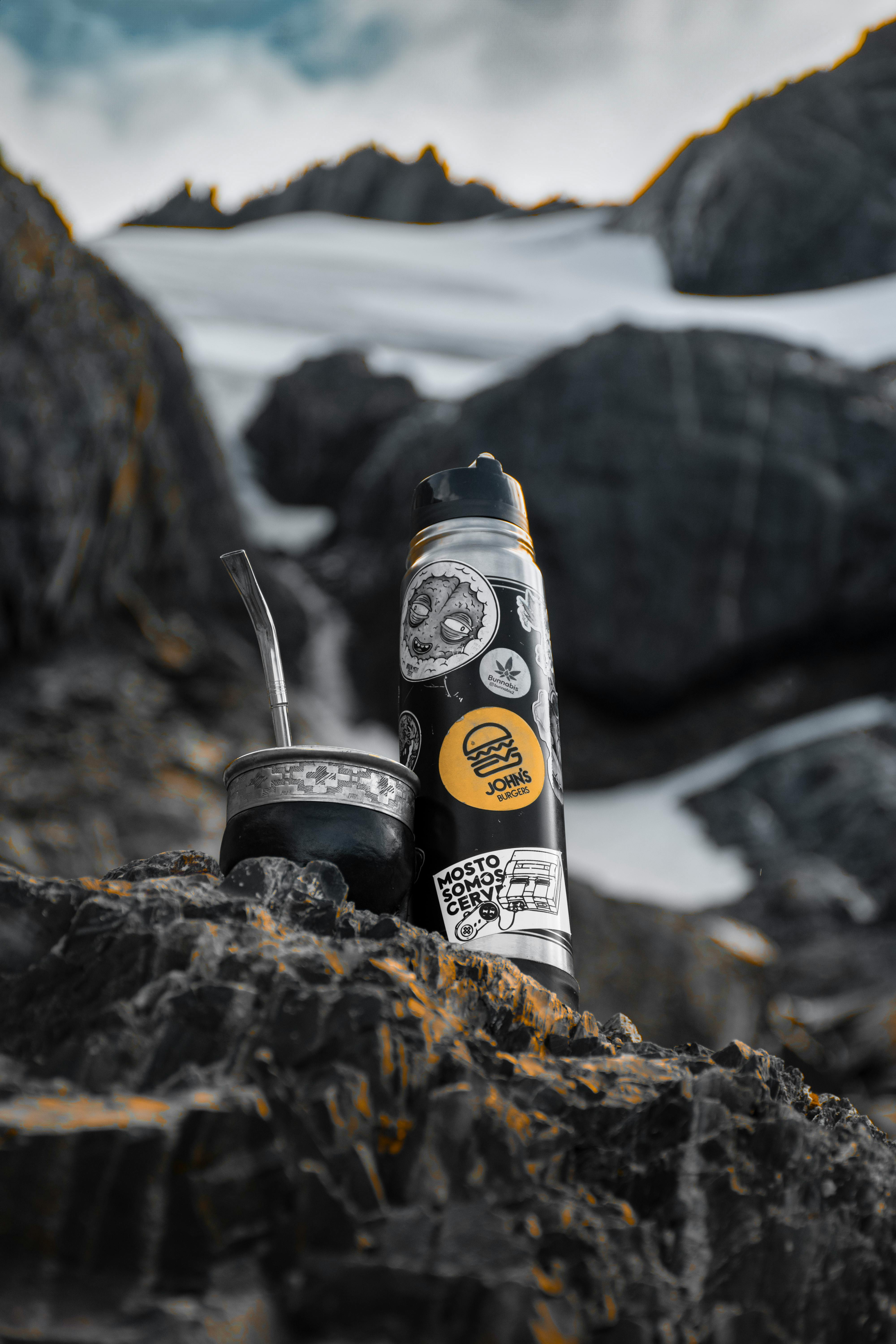 Thermos with Stickers and Mate Cup on Rocks · Free Stock Photo