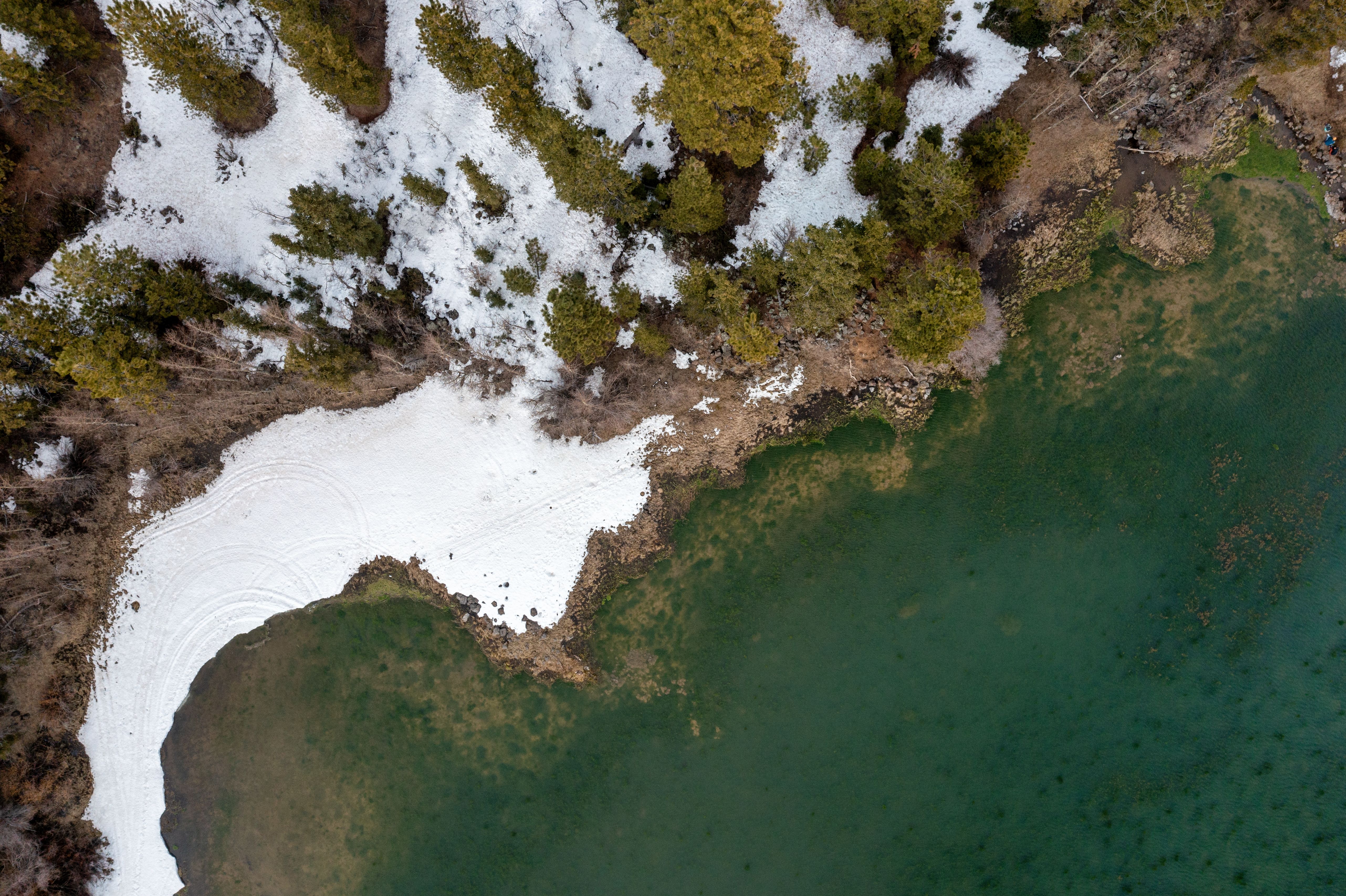 An aerial view of a body of water with snow on it · Free Stock Photo