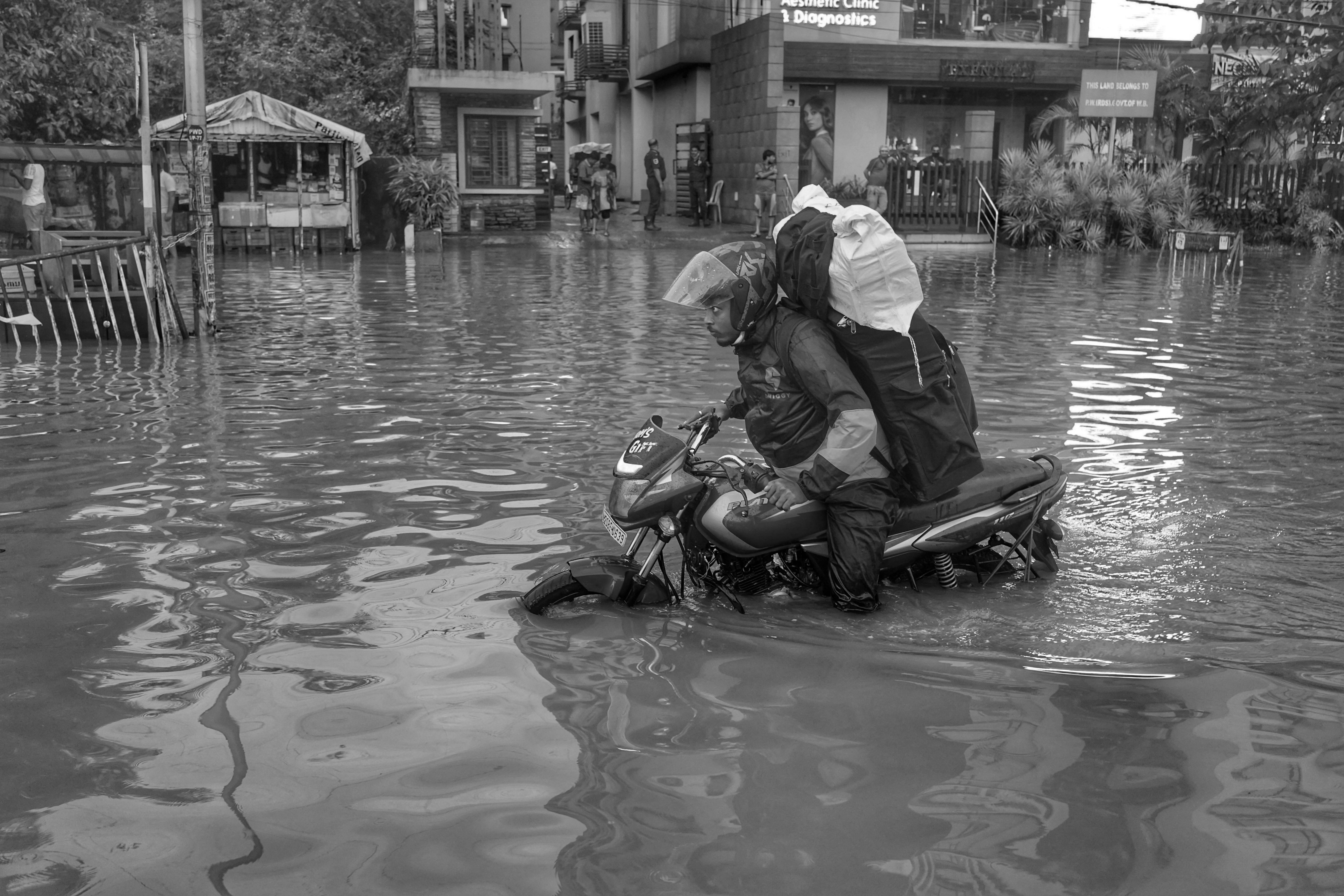 Man Driving on a Motorcycle Through the Flooding · Free Stock Photo