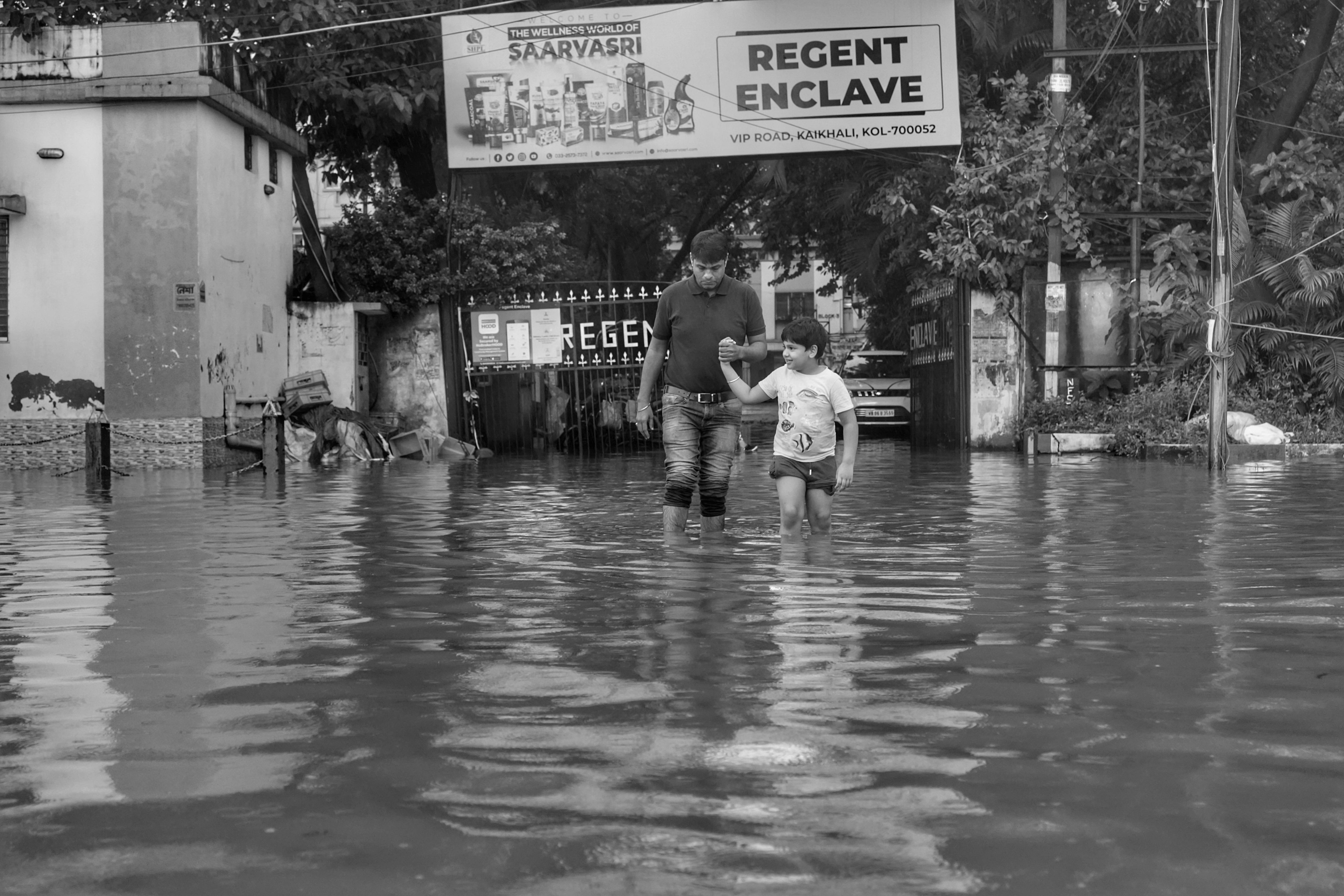 Father and Son Walking Through the Flooding · Free Stock Photo