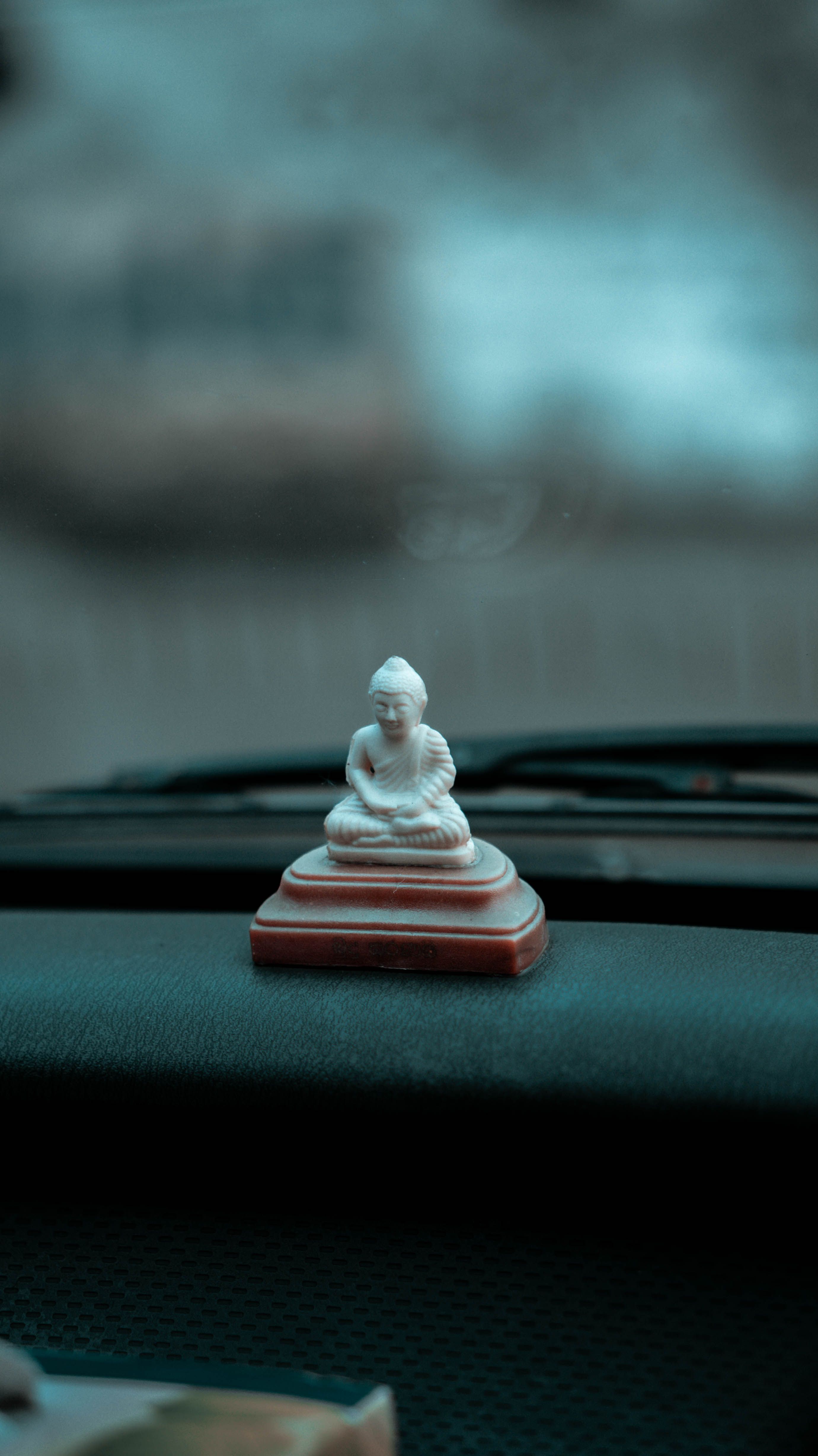 Close-up of a Buddha Figurine on a Dashboard of a Car · Free Stock Photo