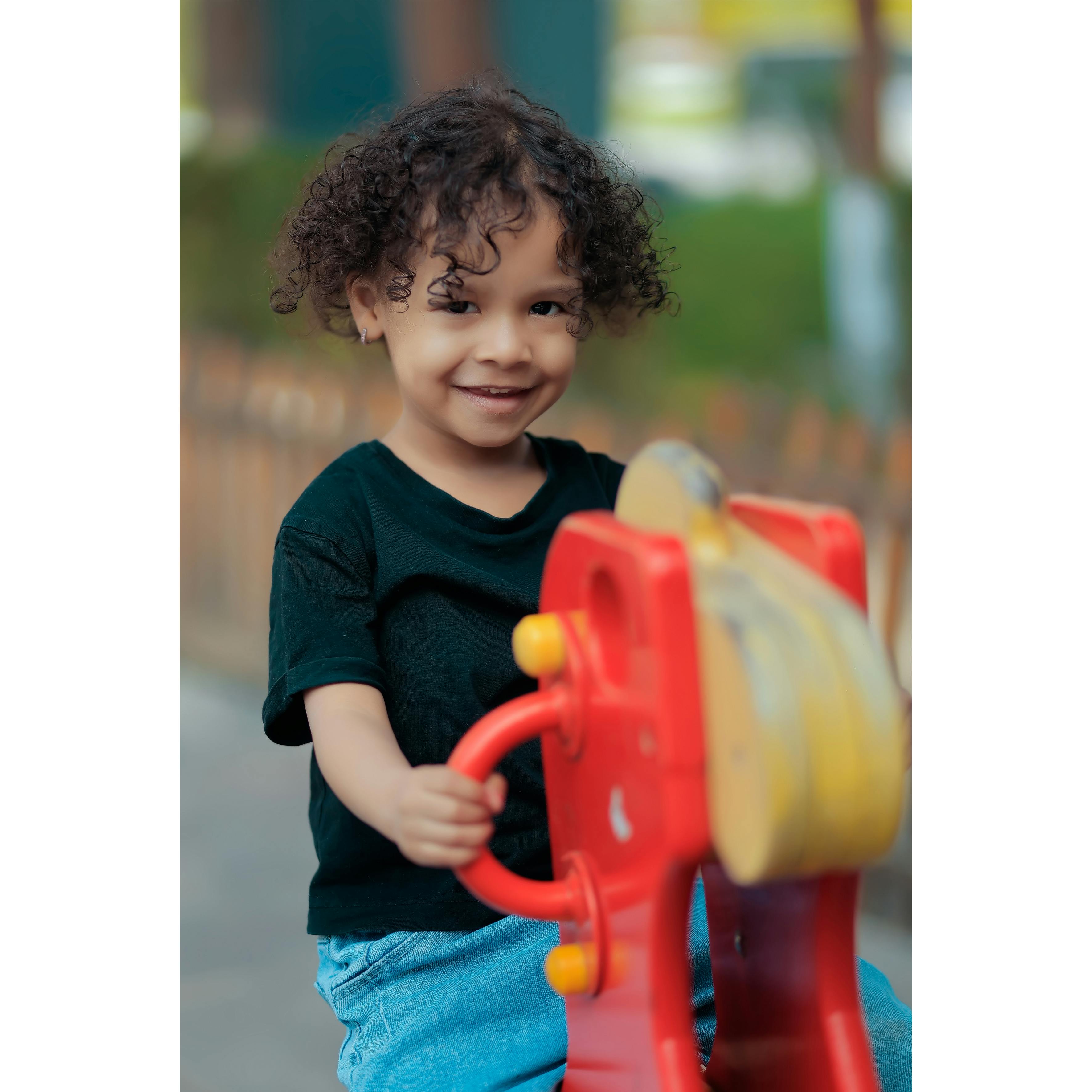 Smiling Boy Sitting on a Playground · Free Stock Photo