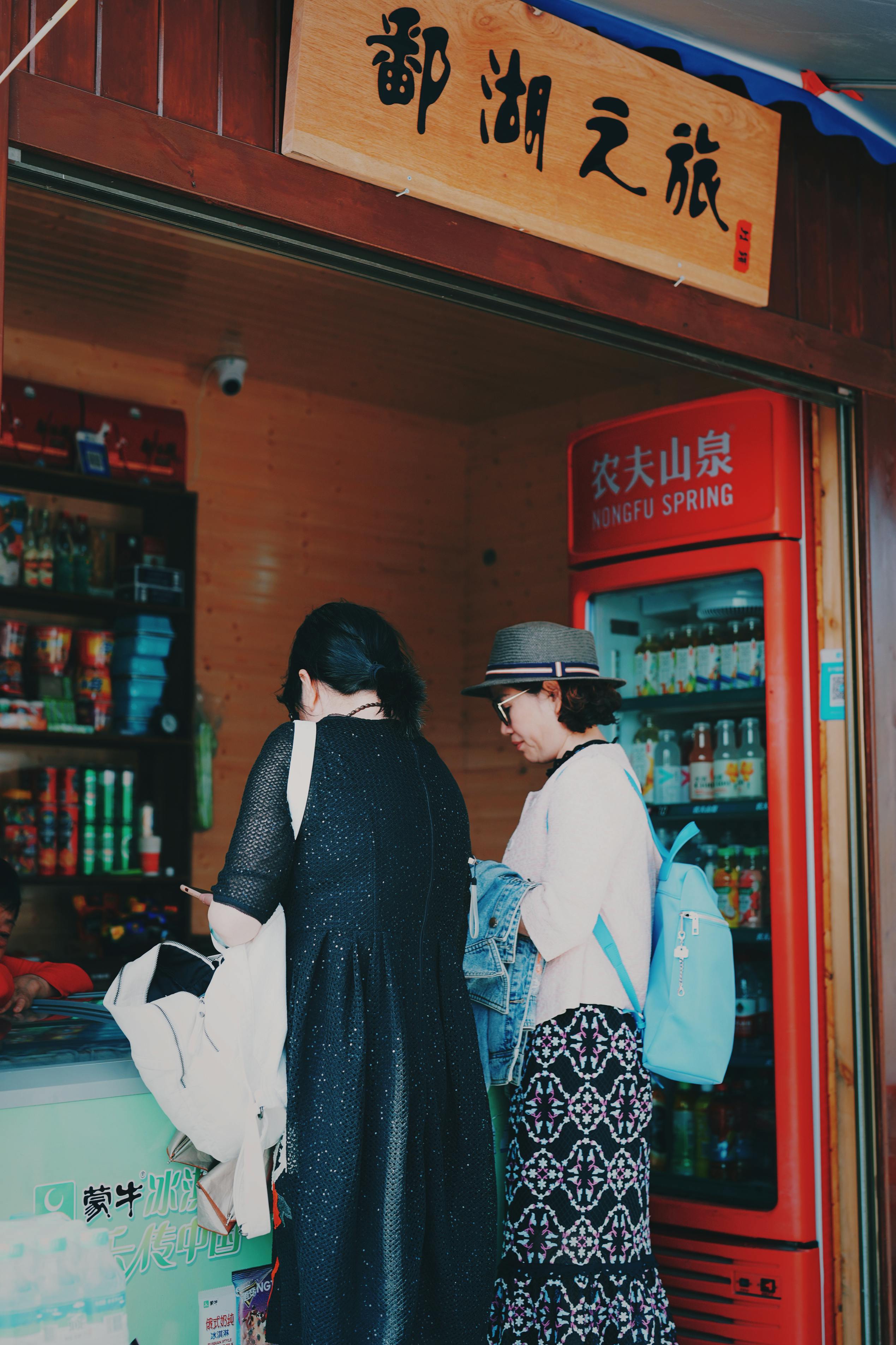 Back View of Women Standing at the Counter of a Small Shop · Free Stock ...