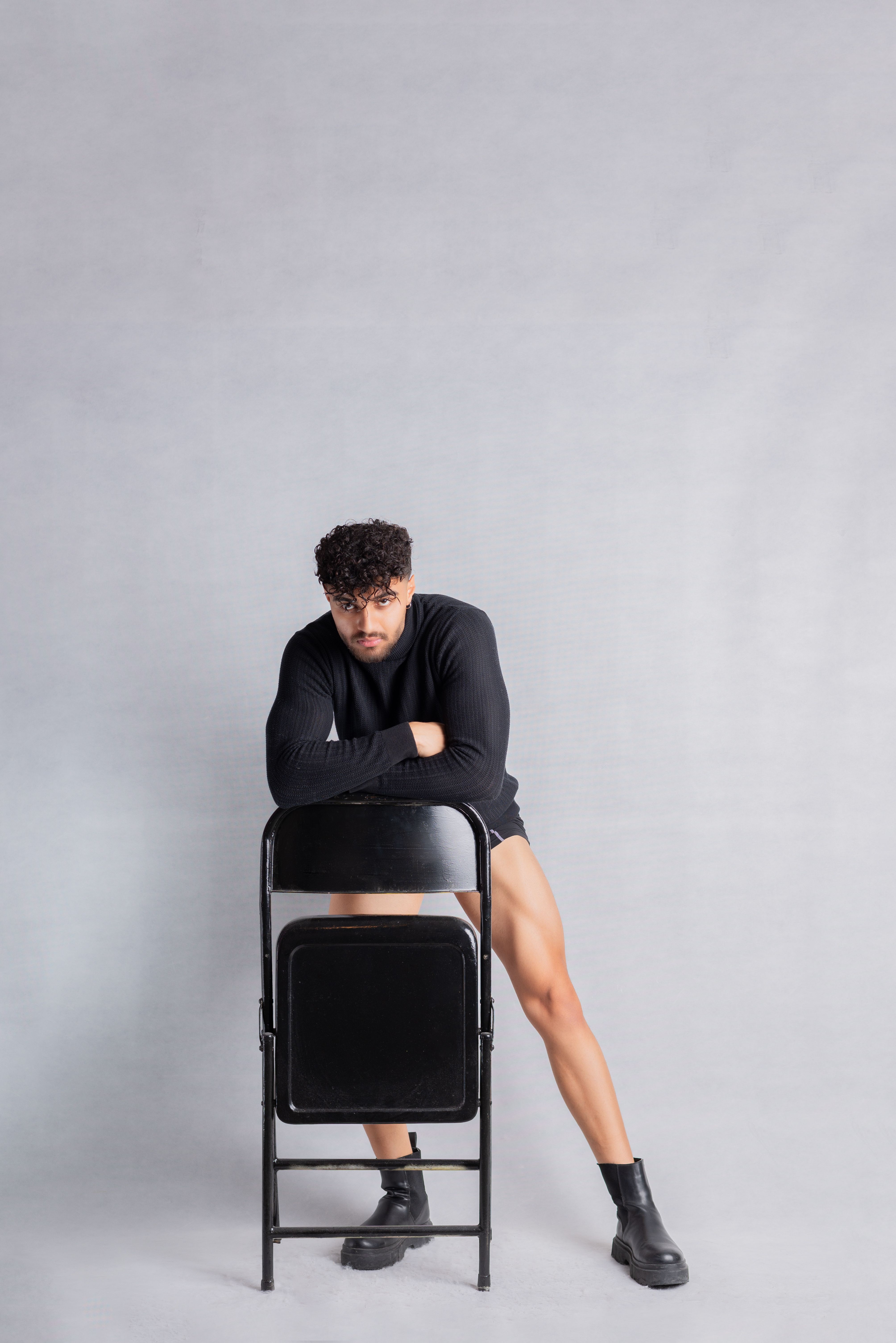 Handsome Man Leaning Against Black Chair · Free Stock Photo