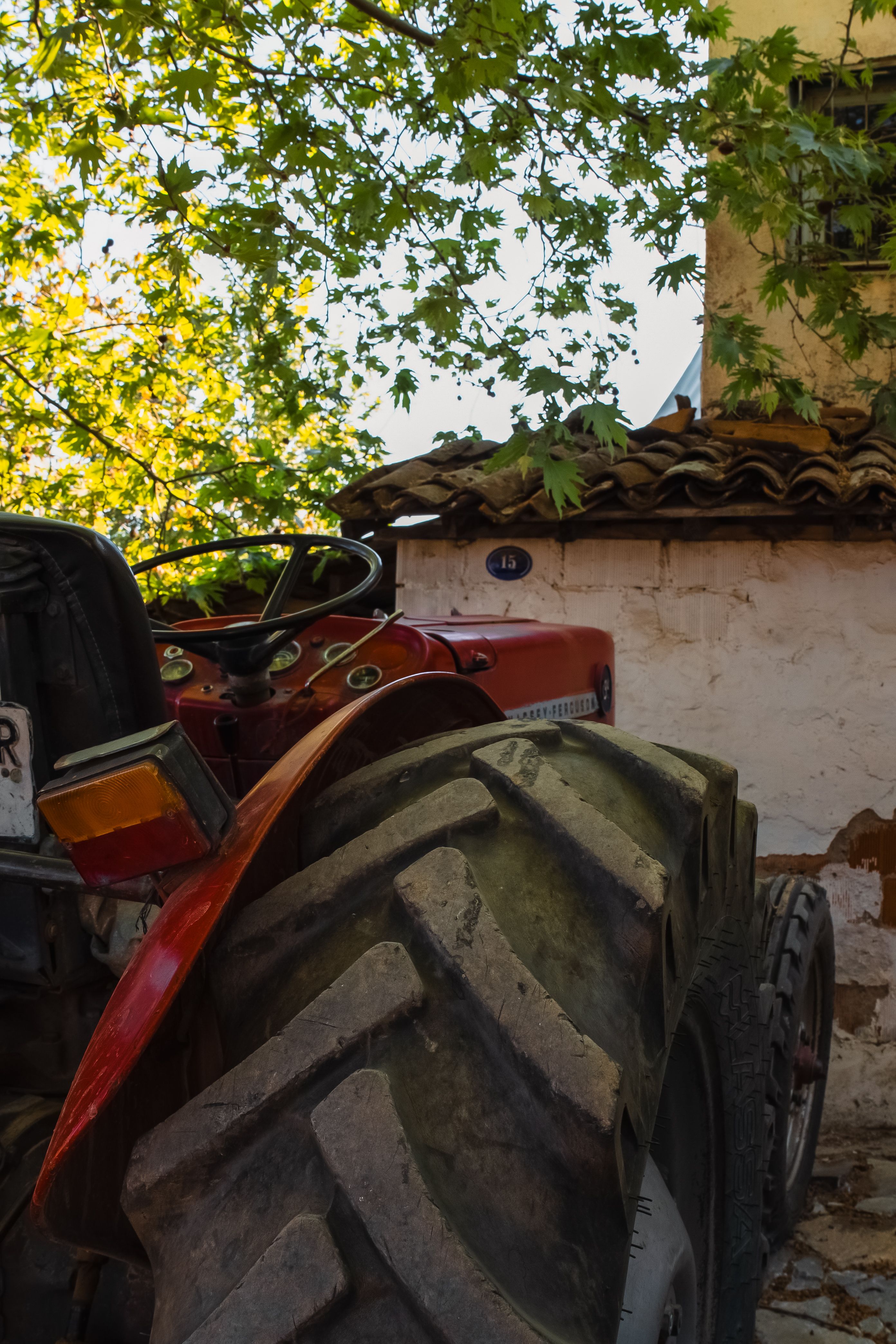 A Red Tractor Against a Building · Free Stock Photo