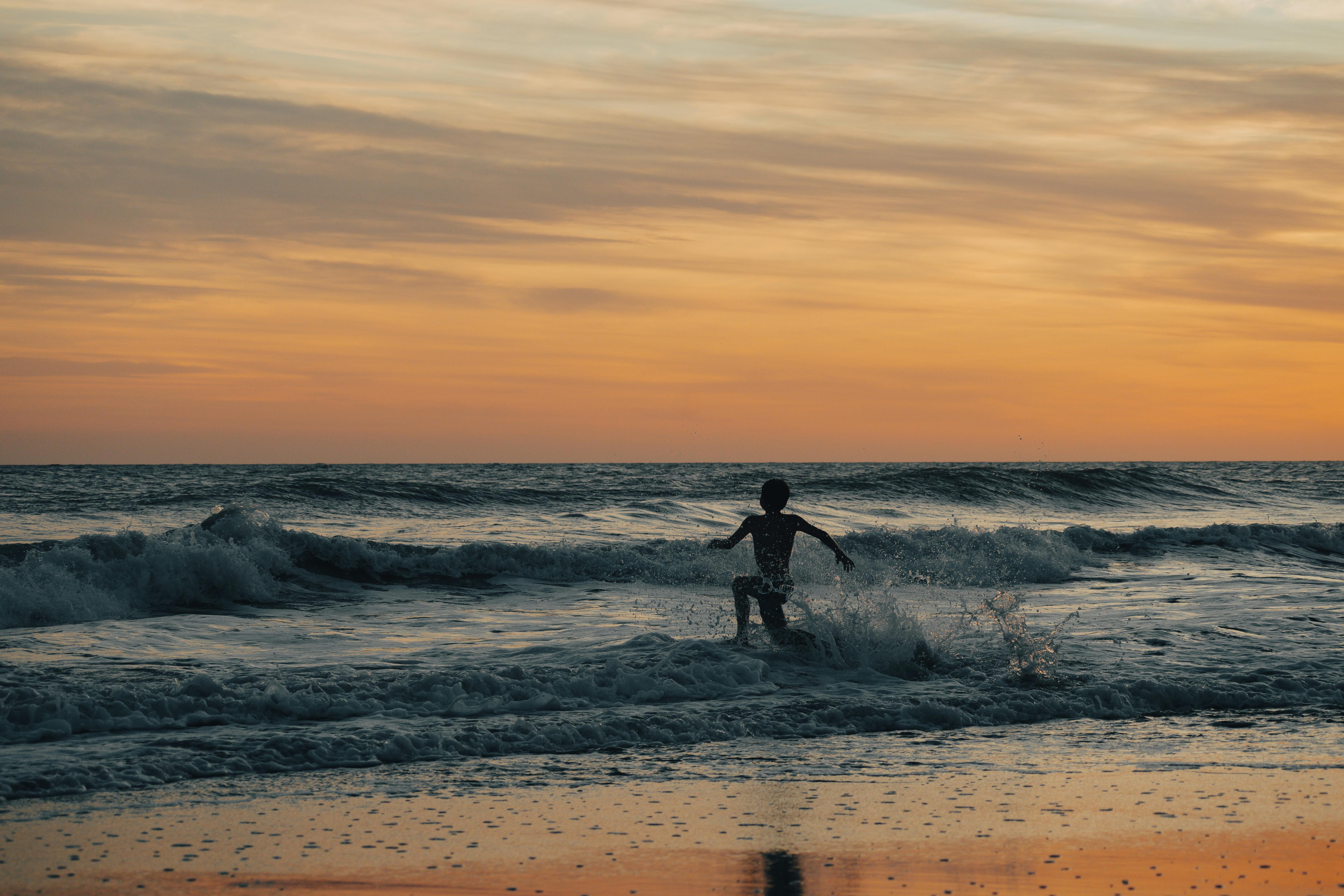 Person Running into Sea in the Evening · Free Stock Photo