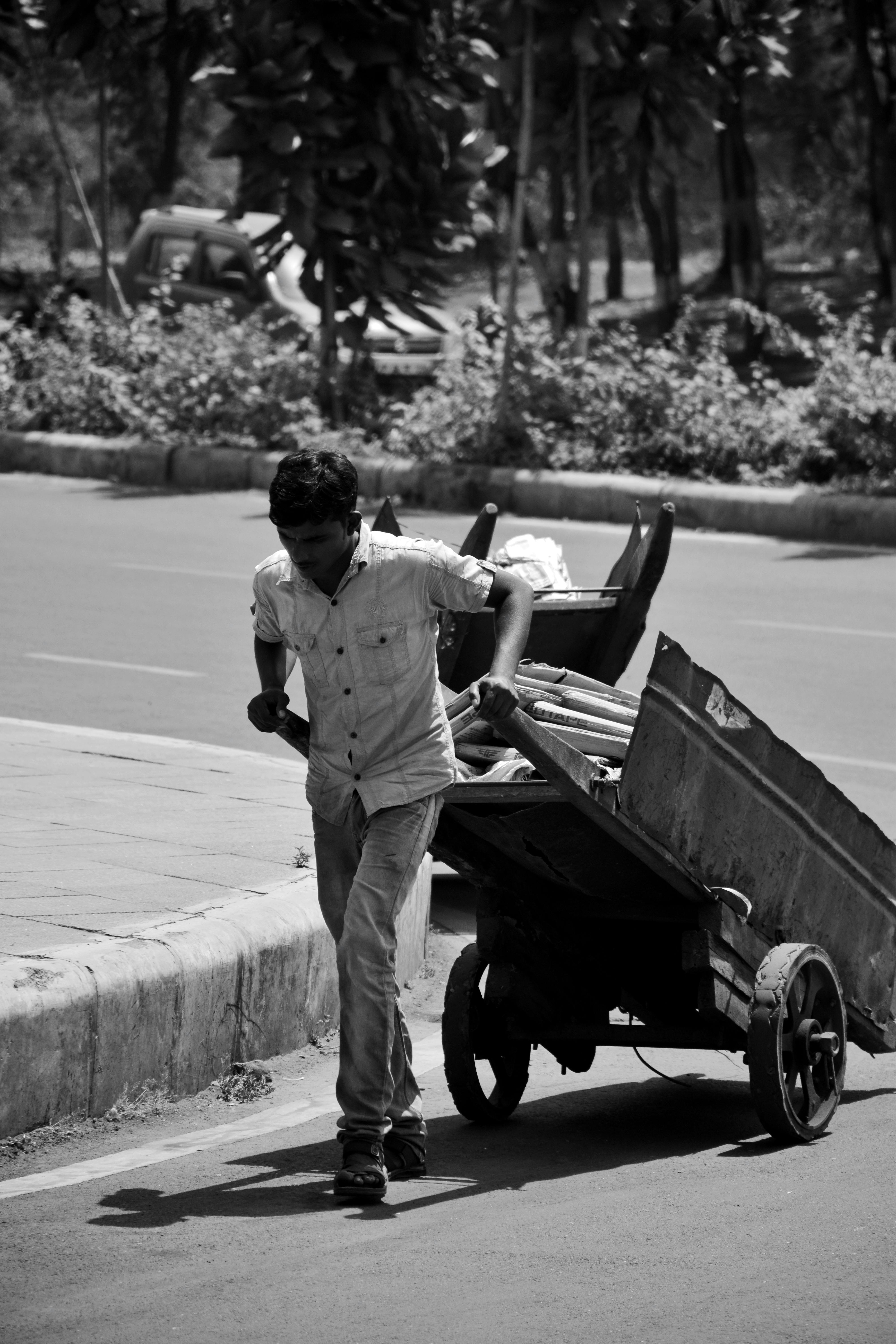 Boy Walking and Towing Trailer on Street · Free Stock Photo
