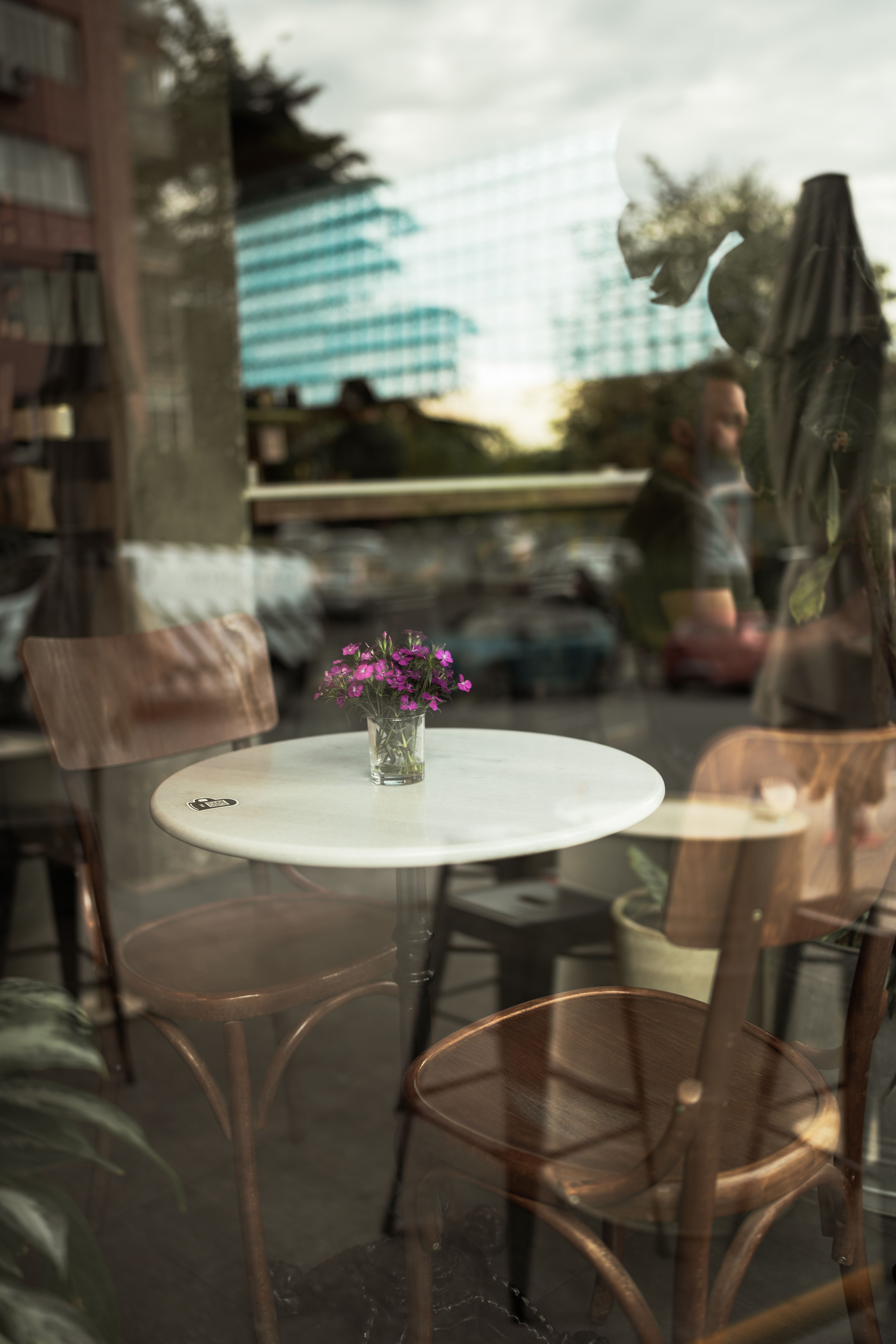 Flowers on Cafe Table behind Window · Free Stock Photo