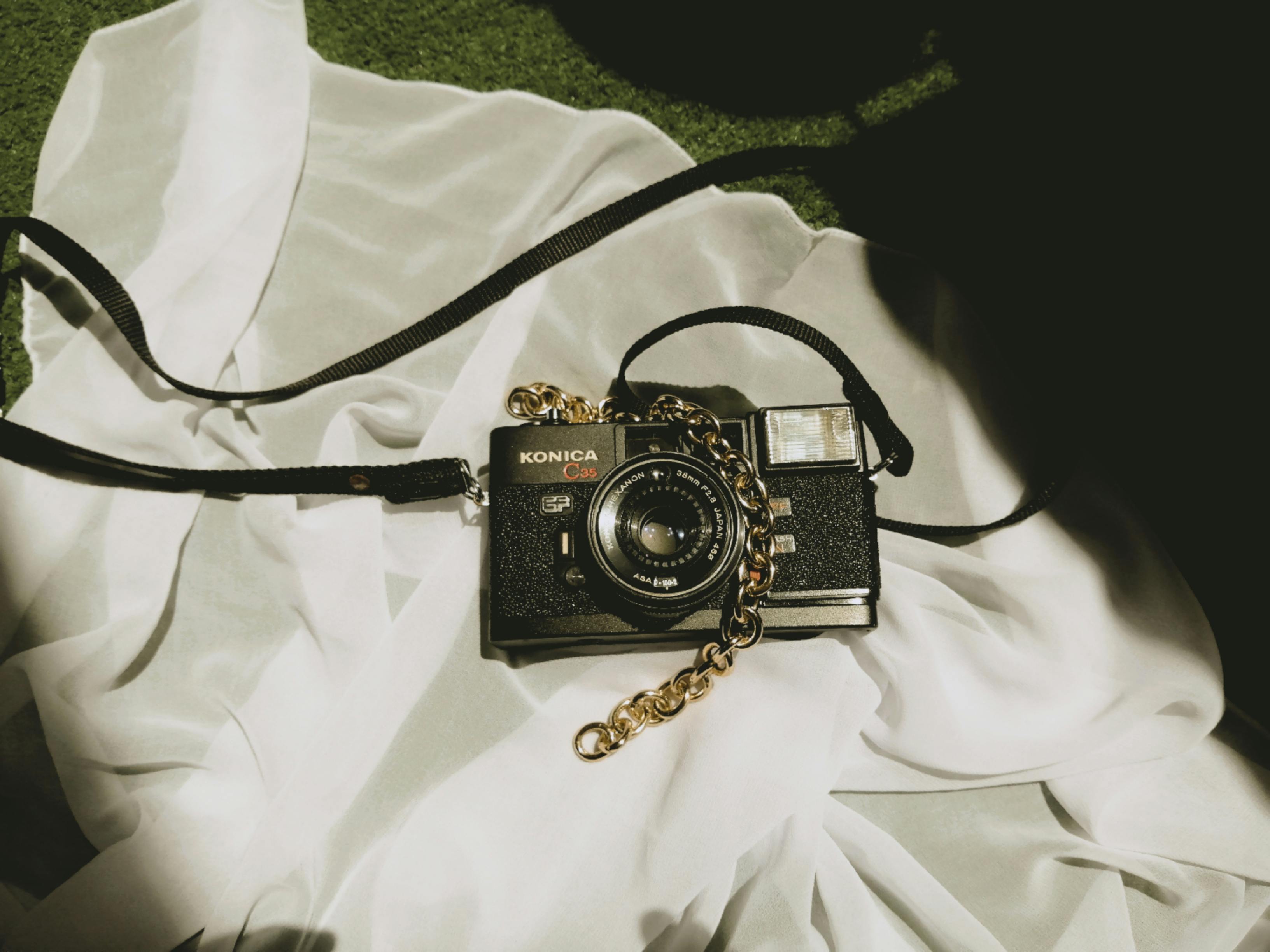 Konica Camera on a White Material · Free Stock Photo