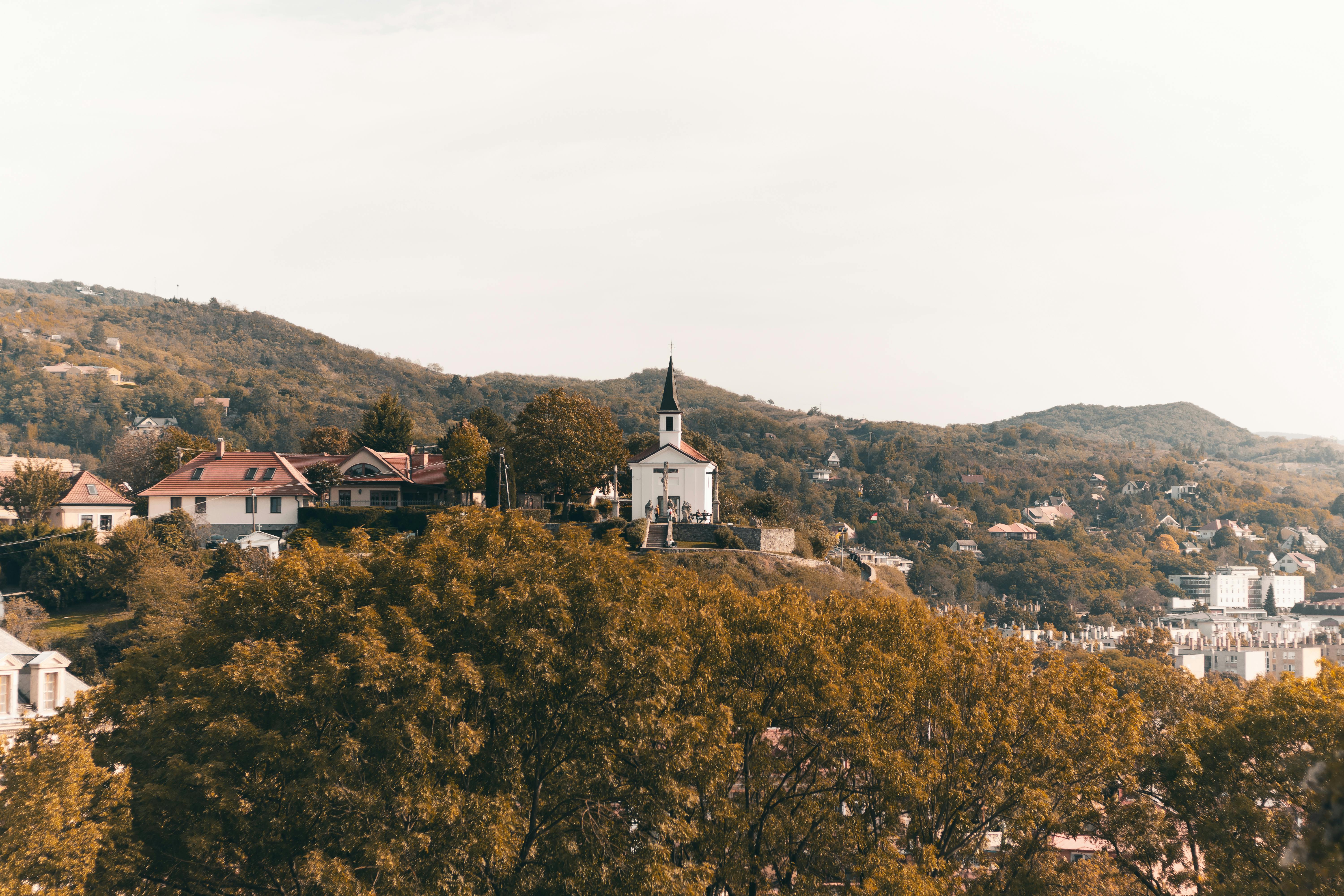 Townscape with a Church, and Hills with Trees · Free Stock Photo