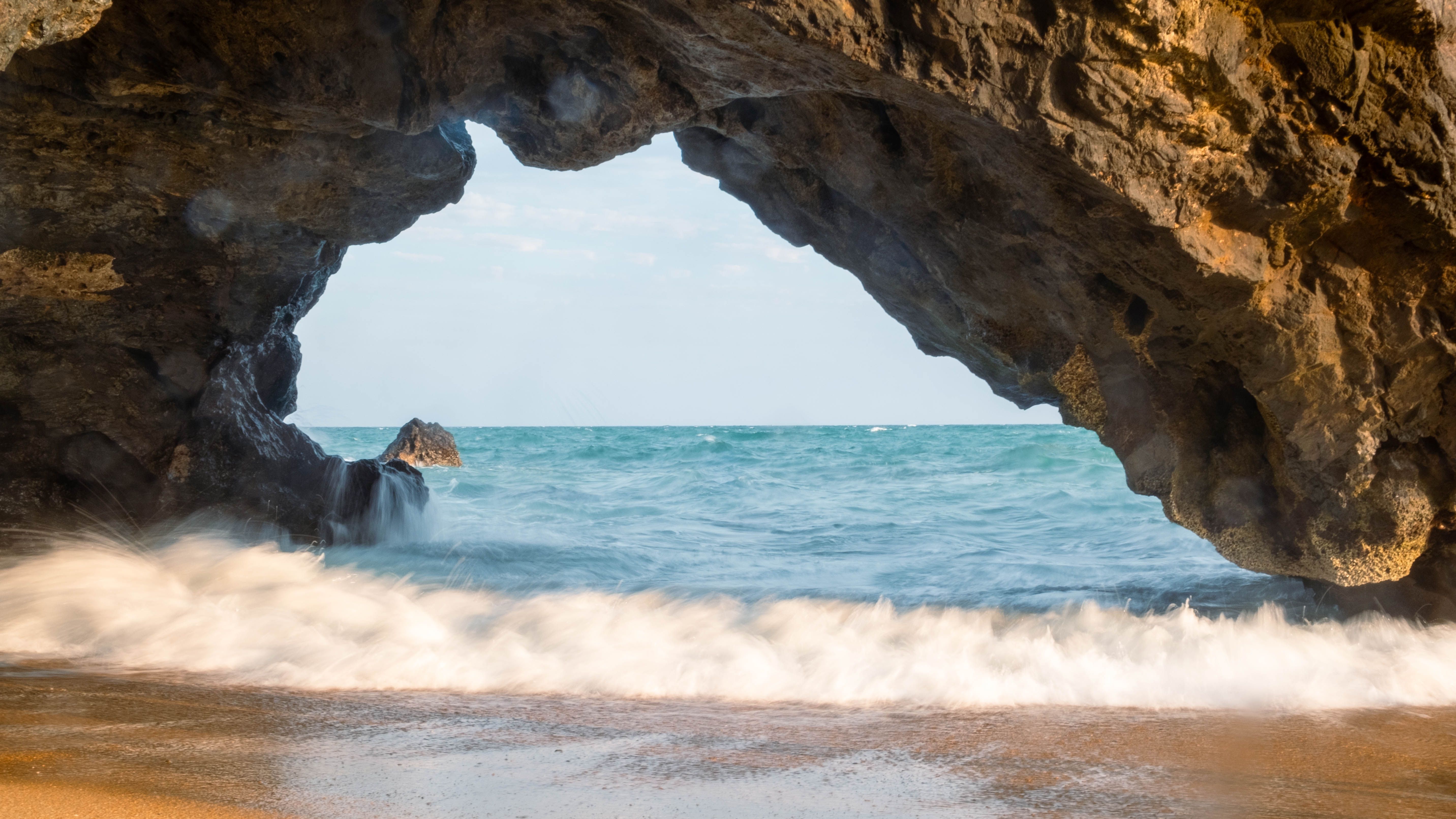 Long Exposure of a Wave Sliding under a Beach Arch · Free Stock Photo