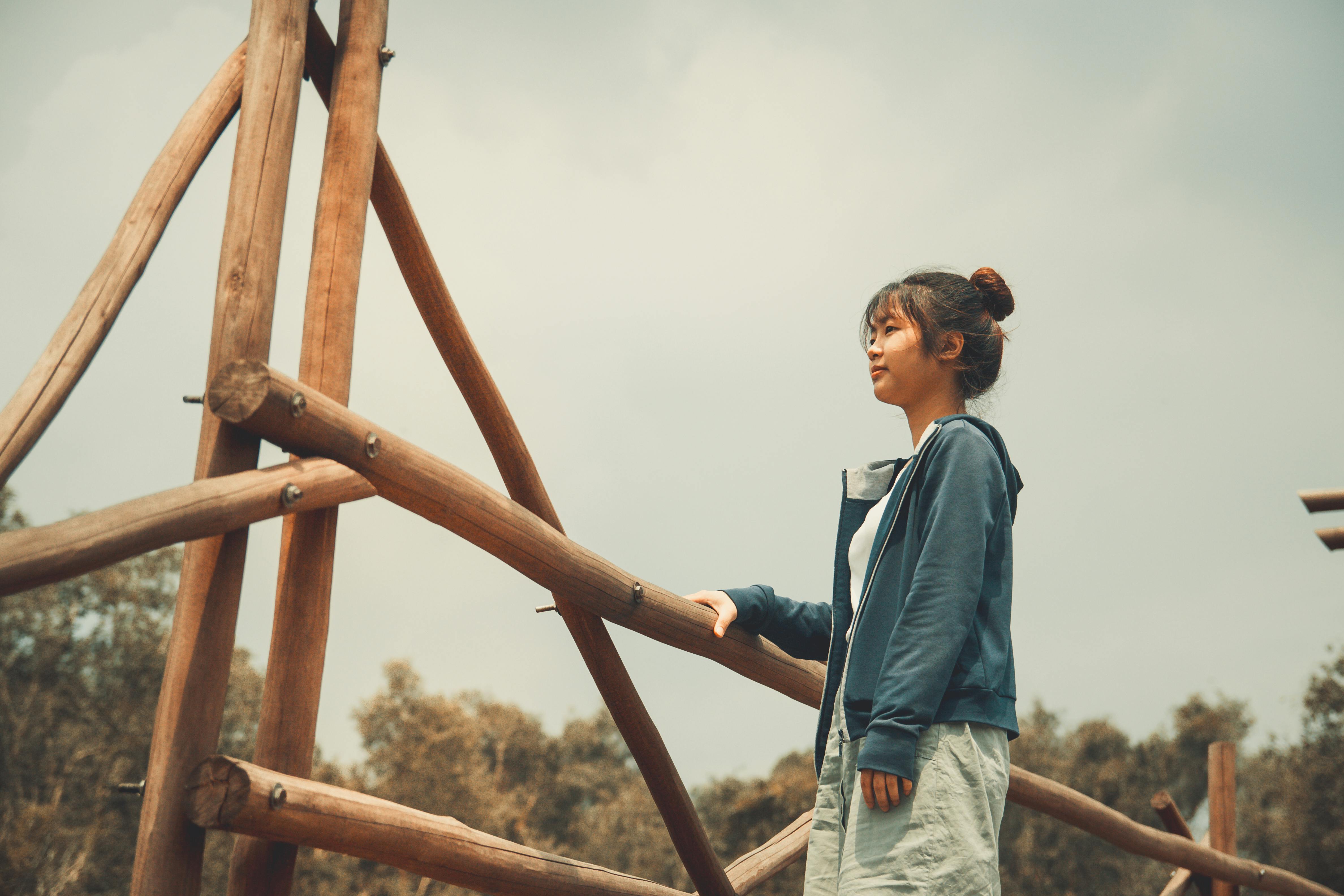 Photo of a Woman Standing Beside Bamboo Post · Free Stock Photo