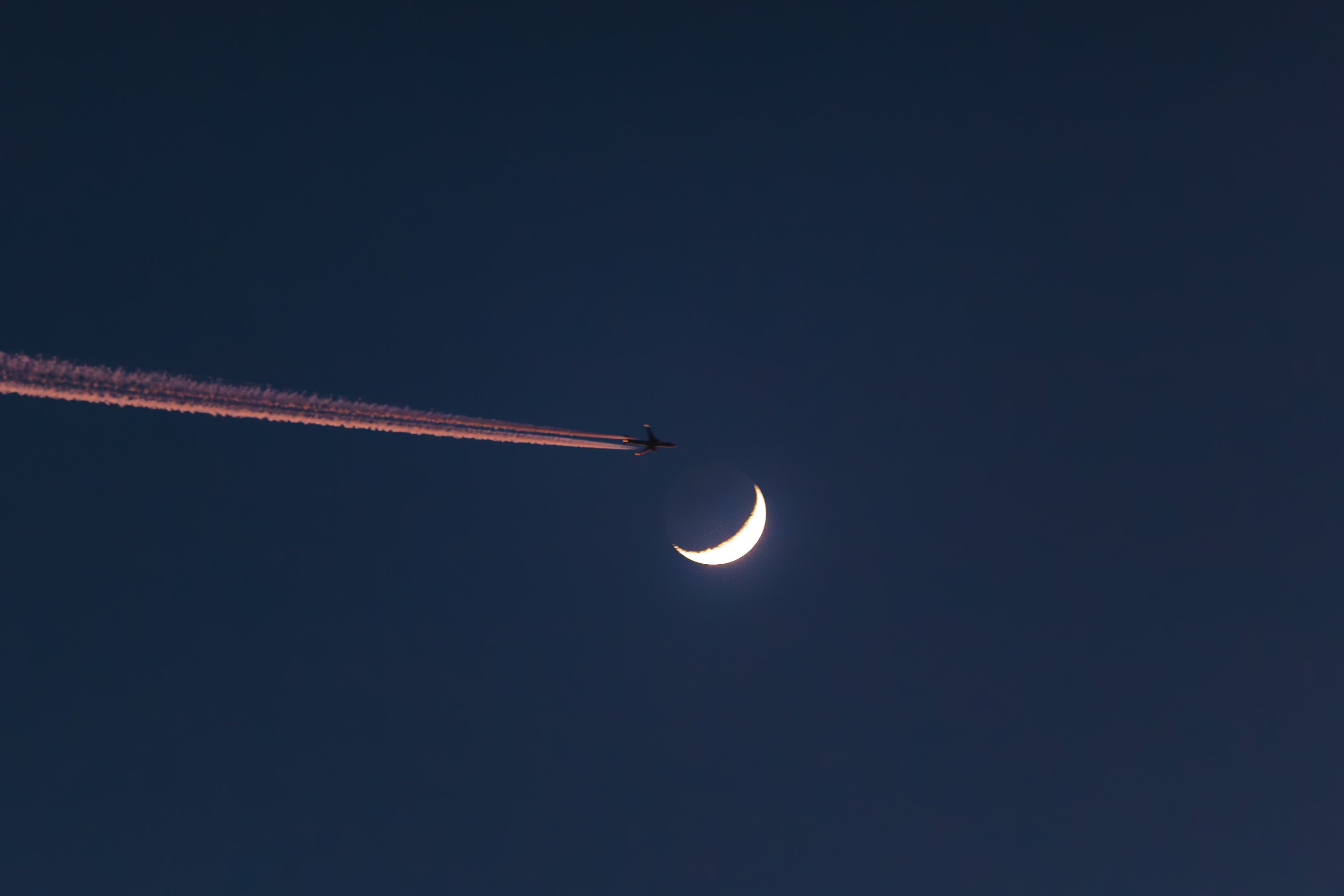 Airplane and Contrails in Night Sky with Crescent Moon · Free Stock Photo