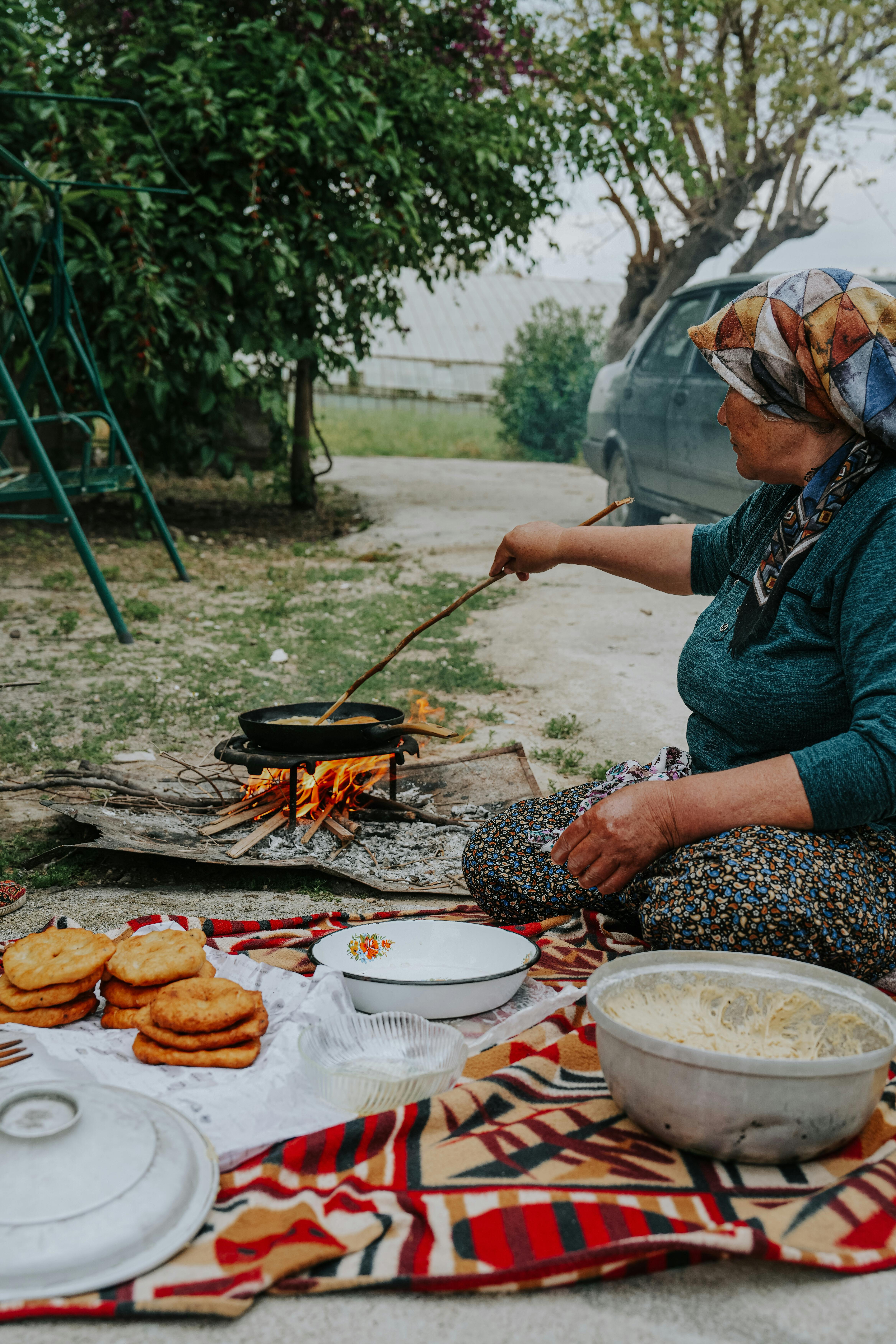 A Woman Cooking Outdoors · Free Stock Photo