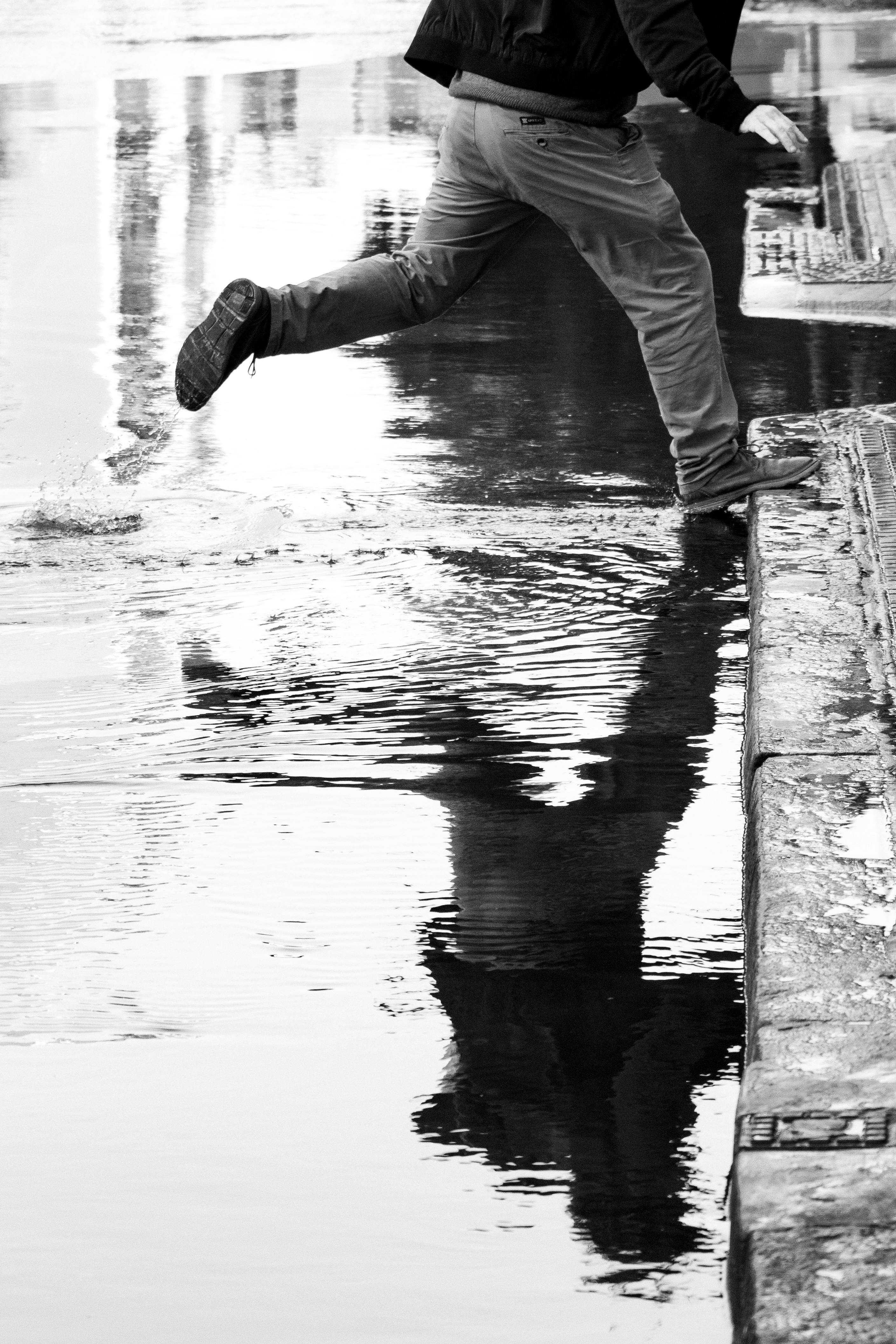 Man Jumping over Puddle · Free Stock Photo