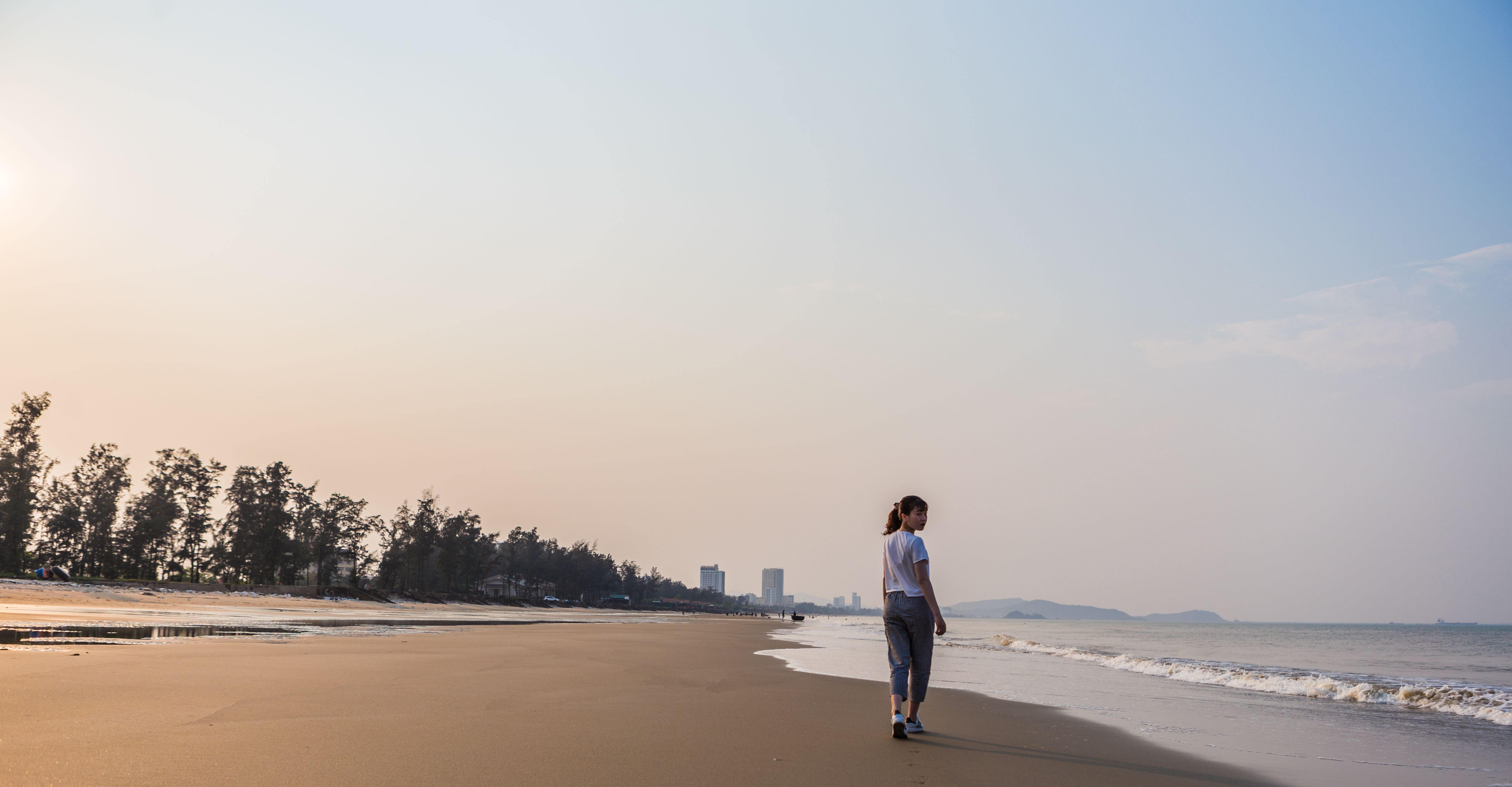 Woman Walking on Shore Near Body of Water · Free Stock Photo
