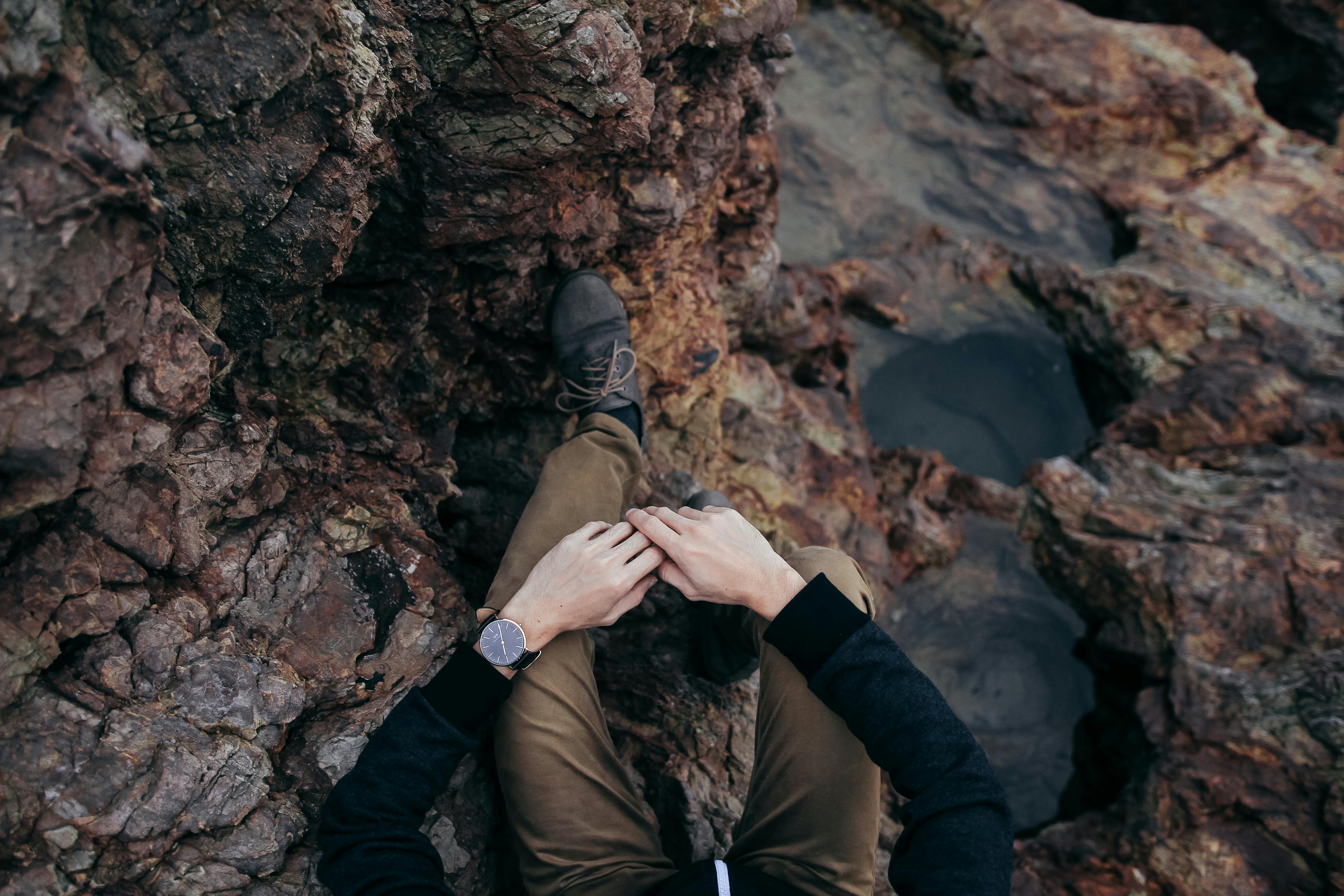 Top View of Man Sitting on Rocks · Free Stock Photo