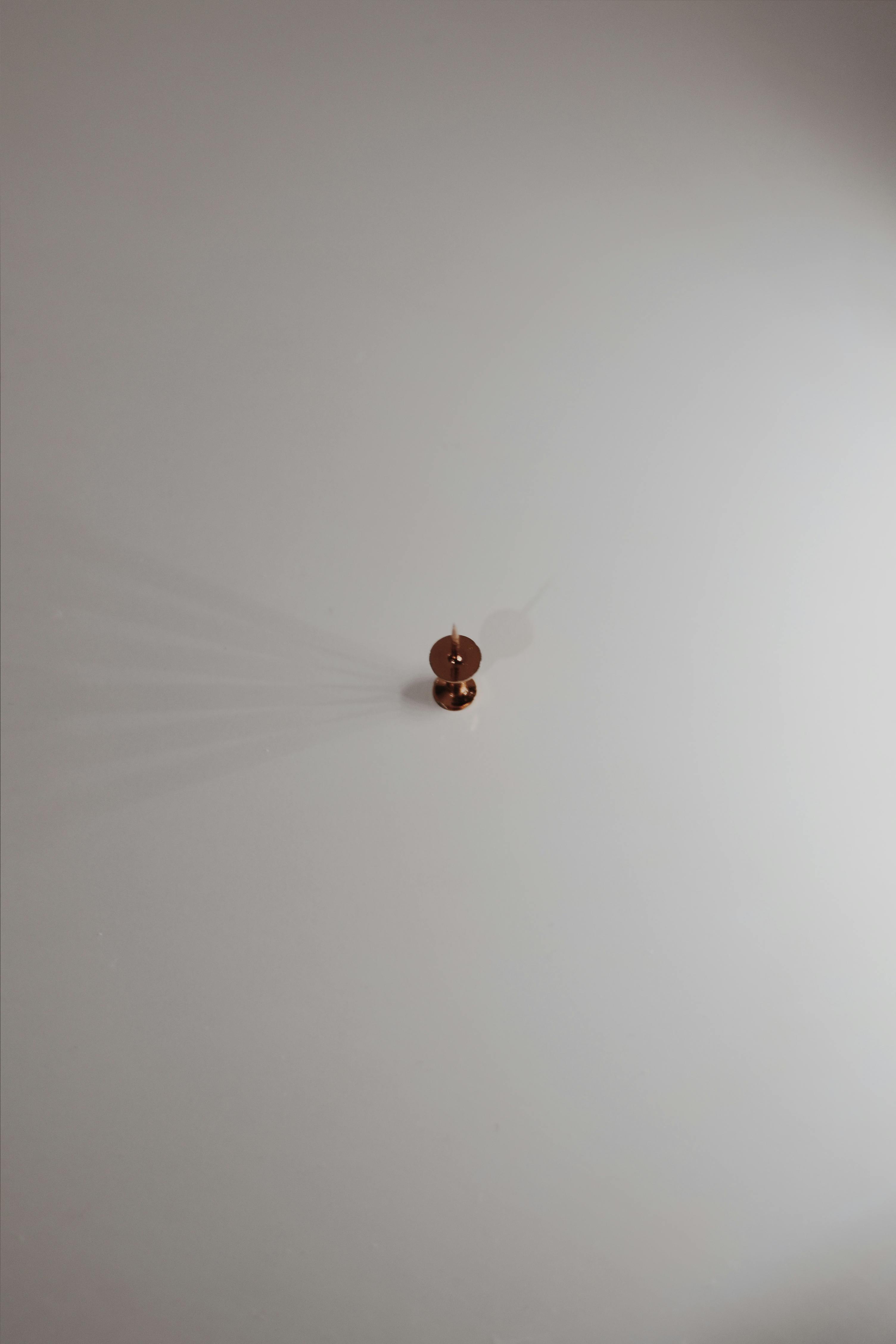 Brown Push Pin on White Surface · Free Stock Photo