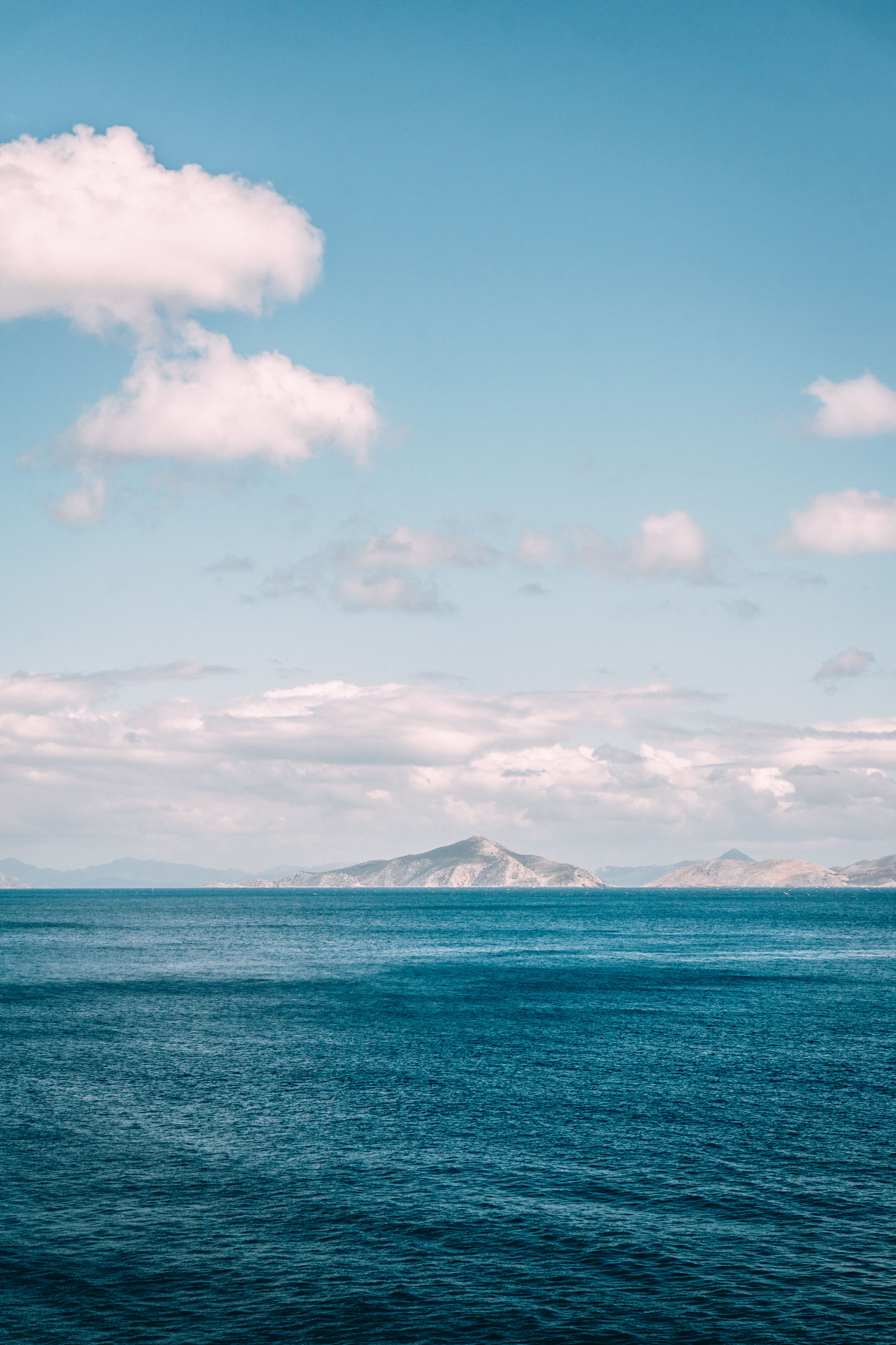 A view of the ocean with a small island in the distance · Free Stock Photo