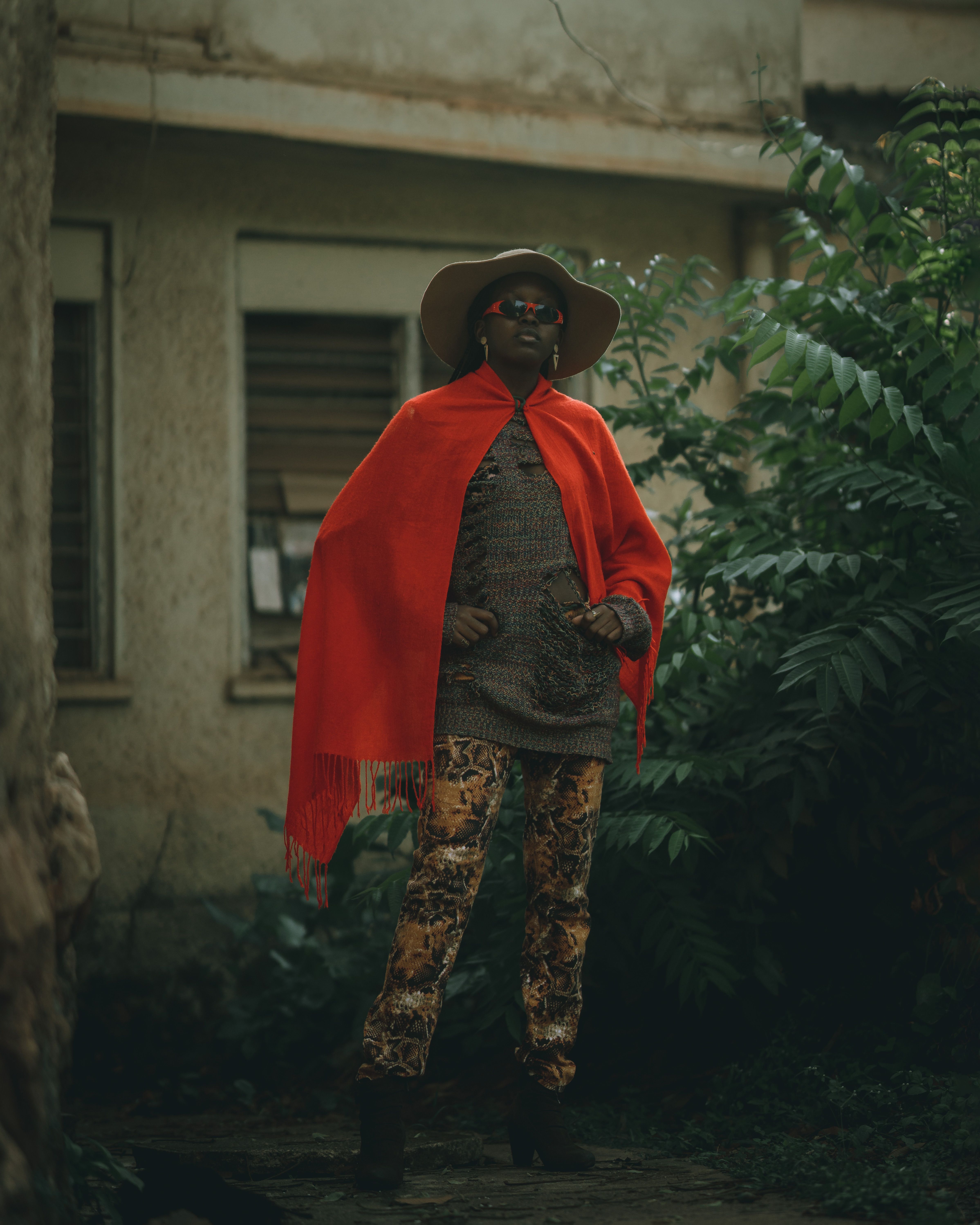 A Woman with a Red Cape Posing in Front of a Building · Free Stock Photo