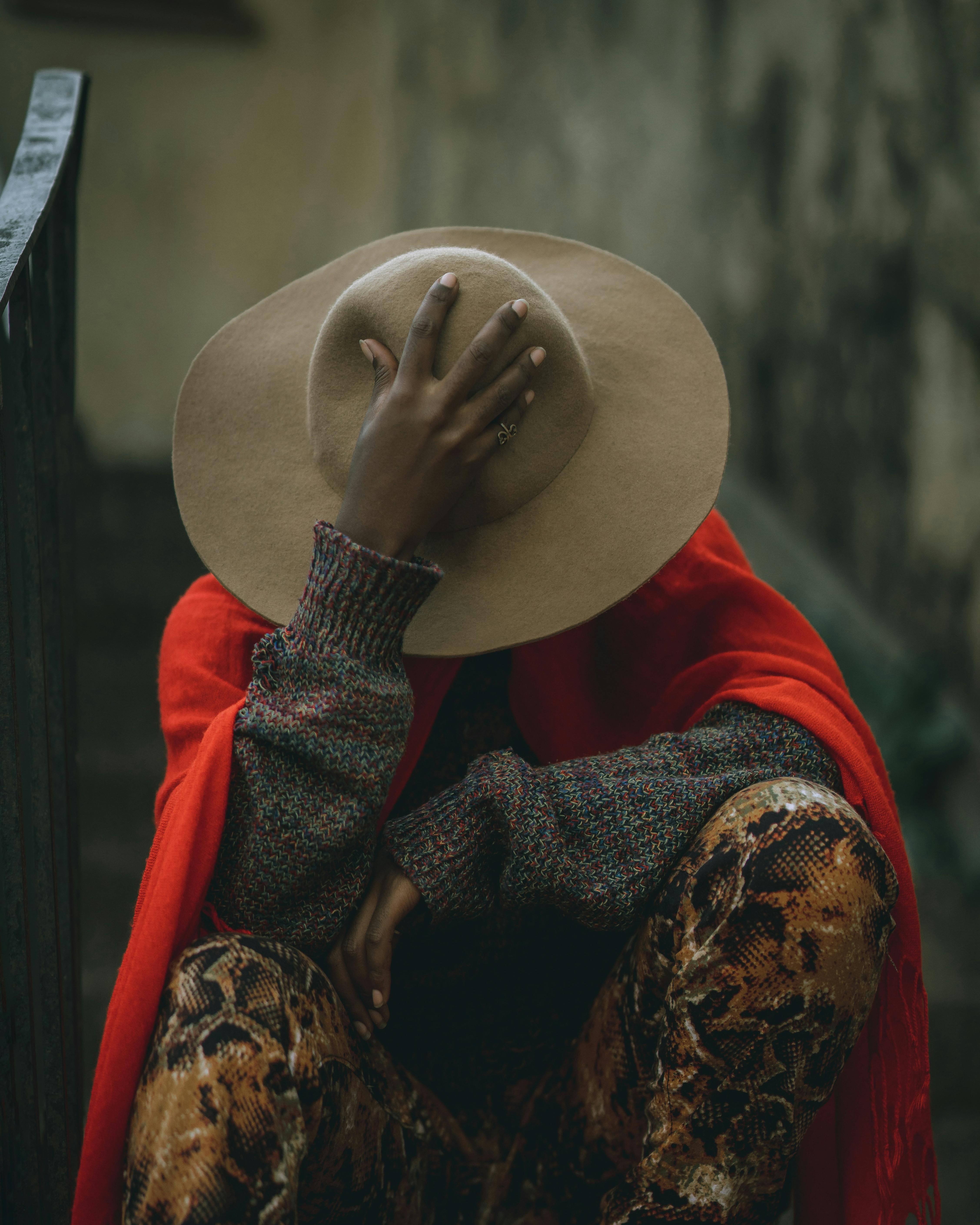 A Woman Hiding Her Face behind a Hat · Free Stock Photo