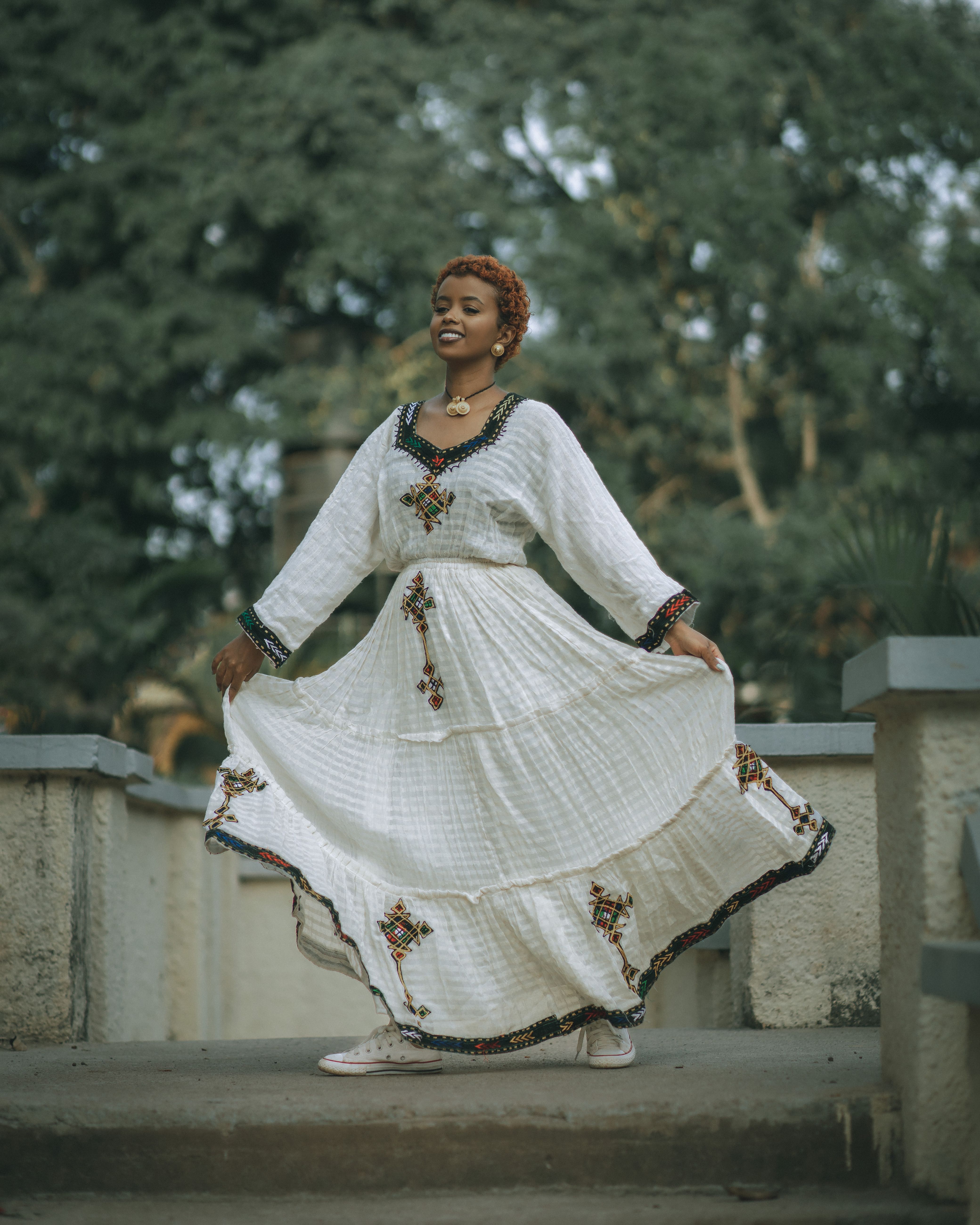 A woman in a long white dress and a headdress · Free Stock Photo