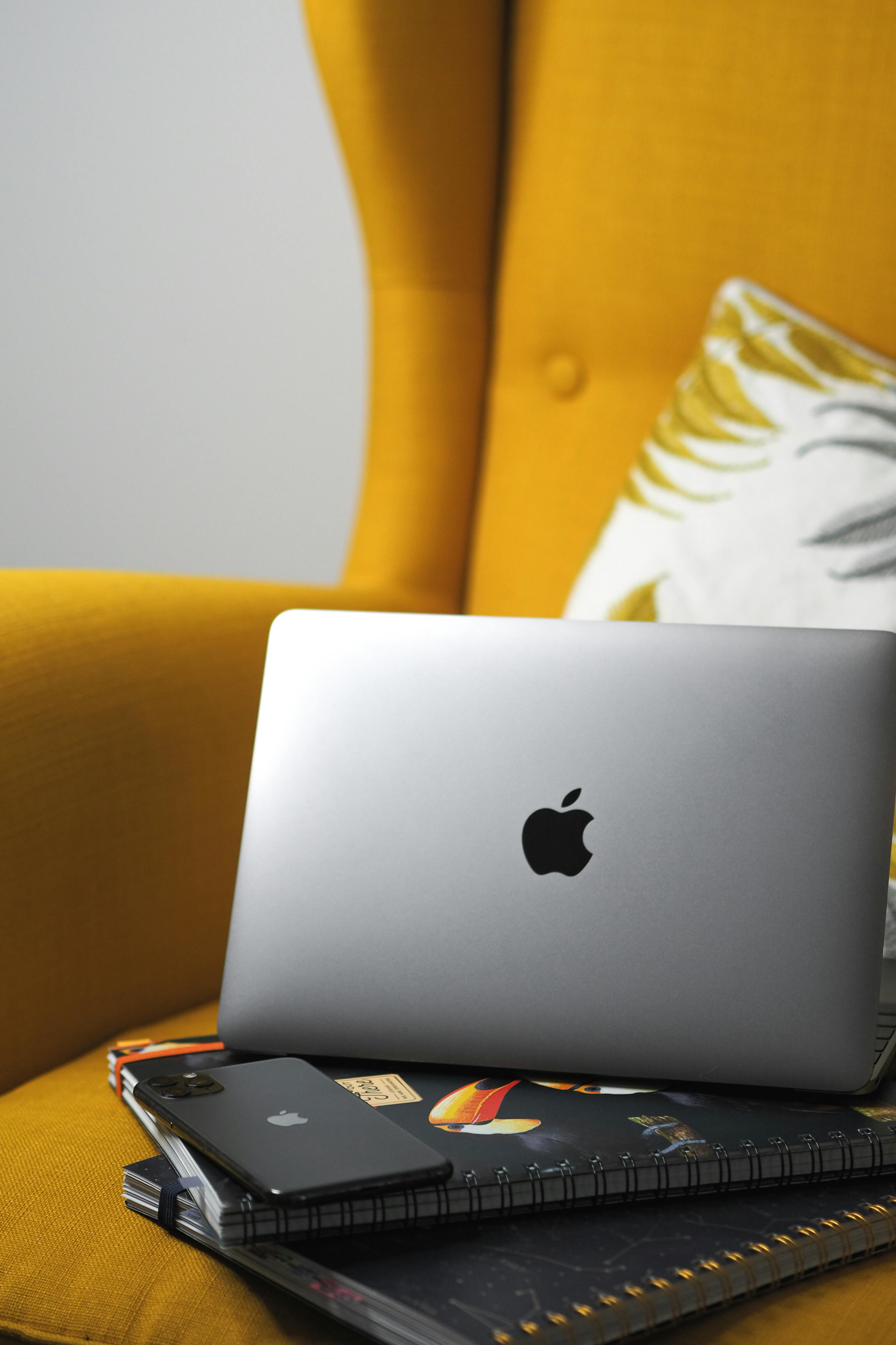 Cozy bed with laptop and notebook · Free Stock Photo