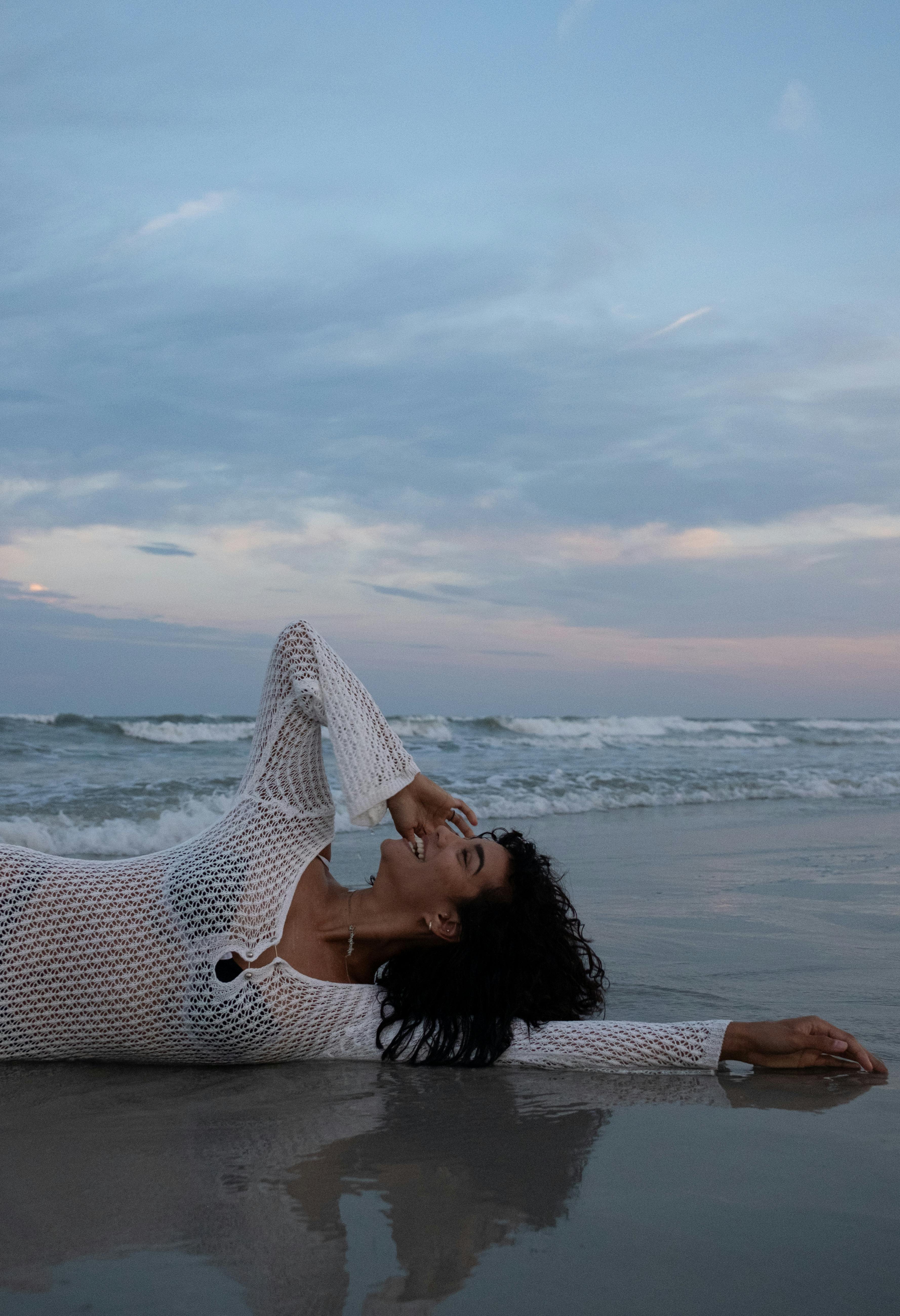 Smiling Woman Lying Down on Sea Shore · Free Stock Photo