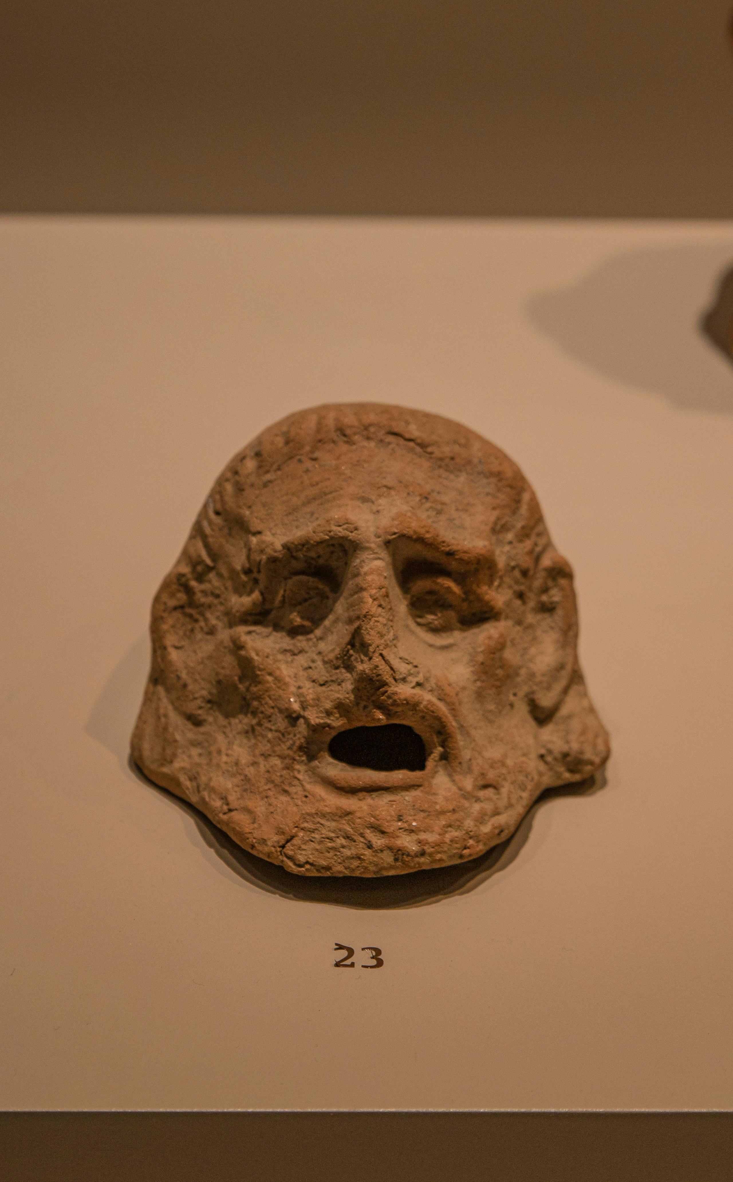 An ancient stone head on display in a museum · Free Stock Photo