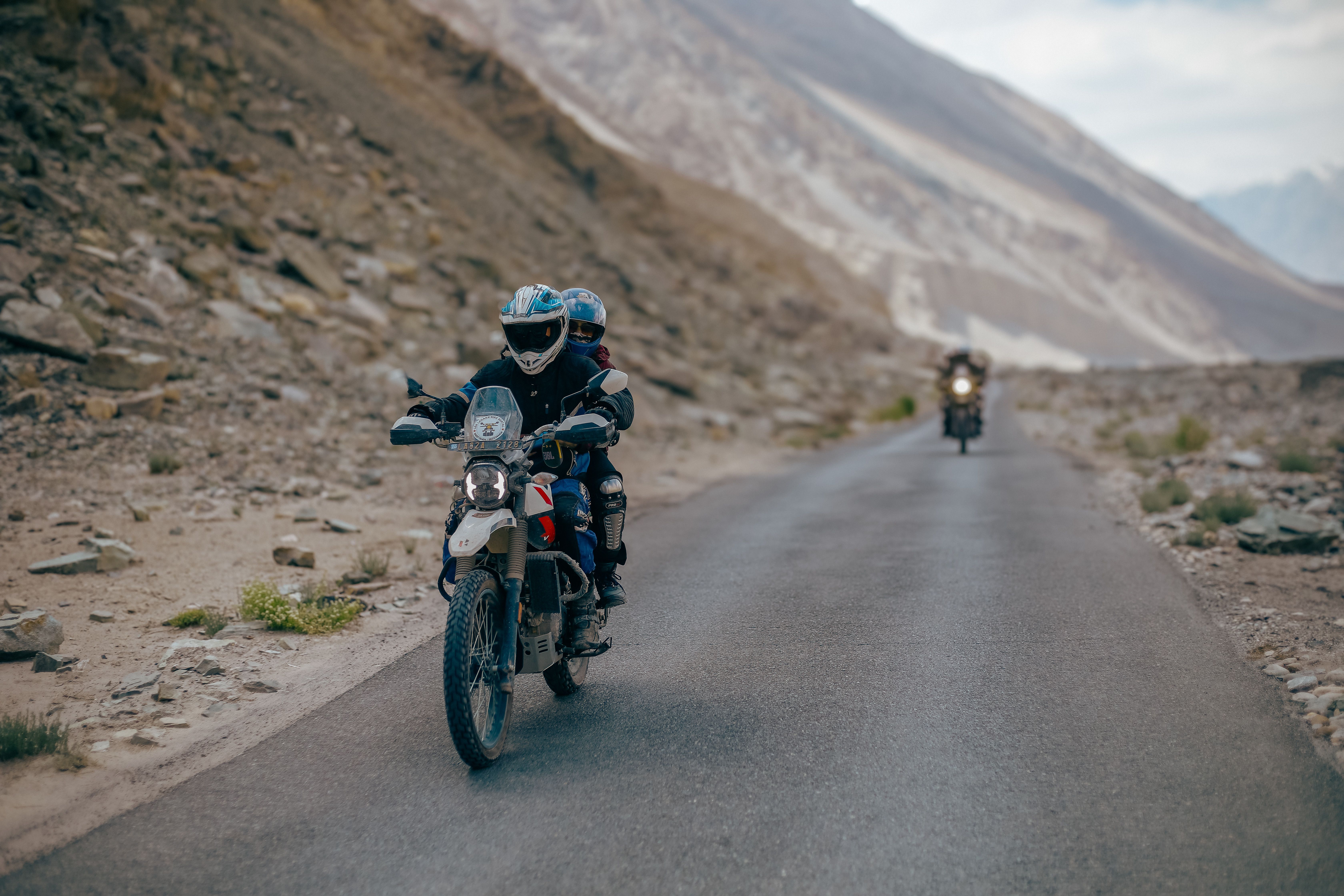 Two people riding motorcycles down a road in the mountains · Free Stock ...