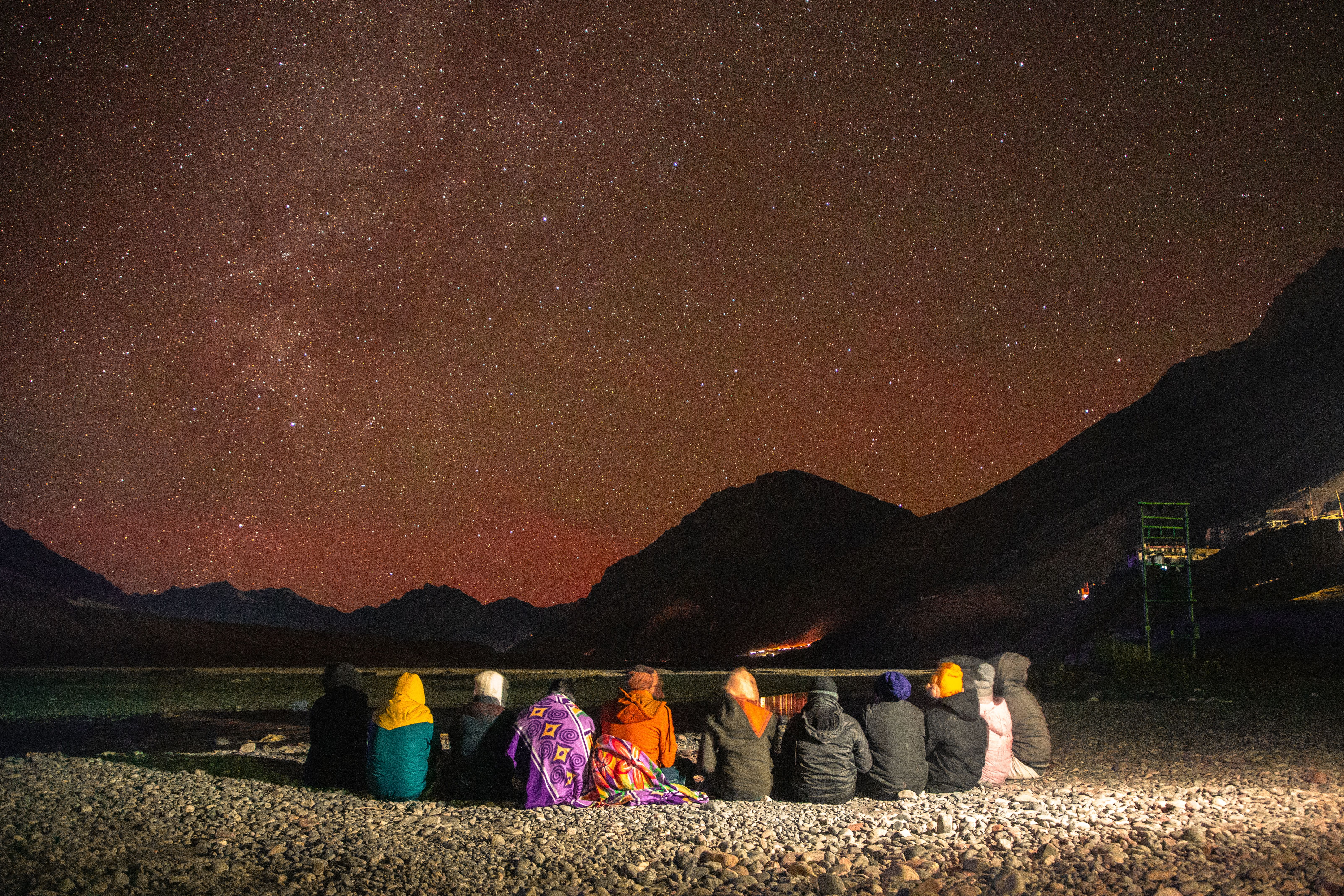 A group of people sitting on the ground under the stars · Free Stock Photo