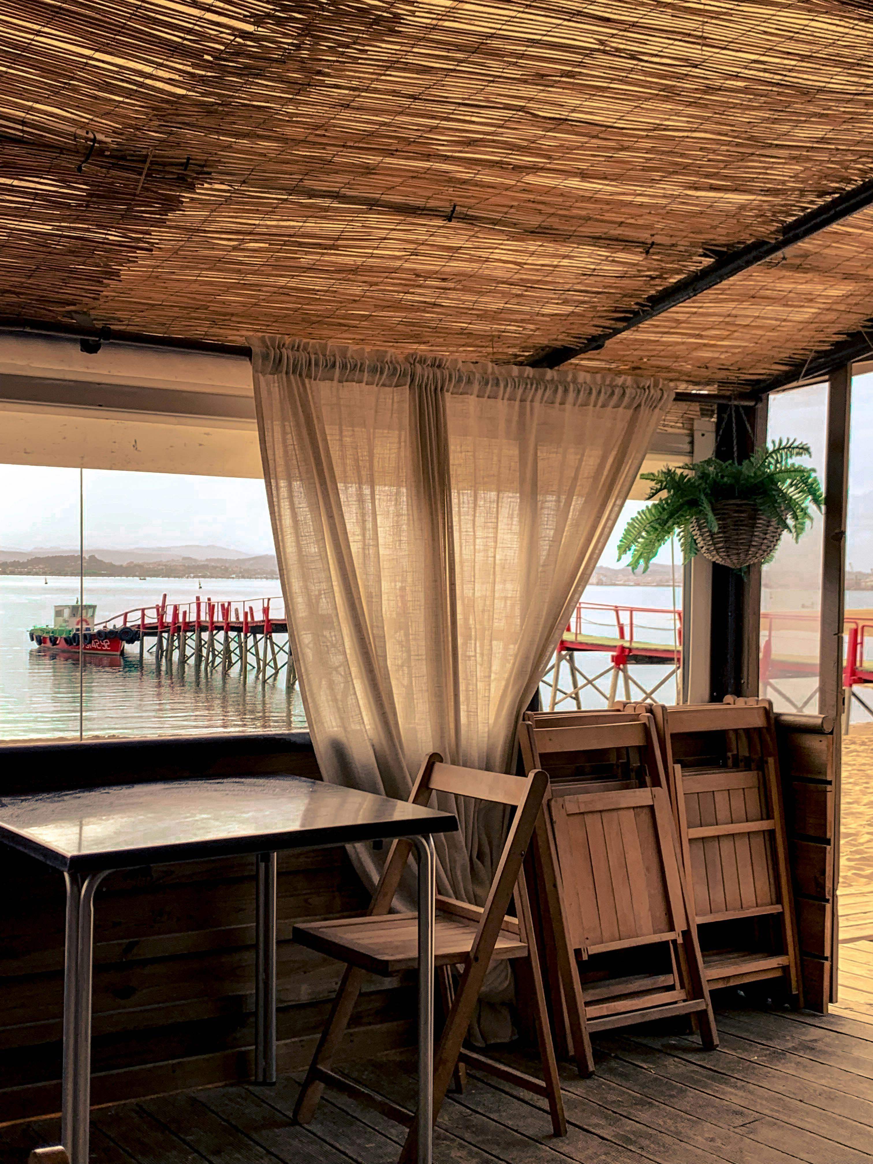 Table and Chair by Windows in Beach Hut · Free Stock Photo