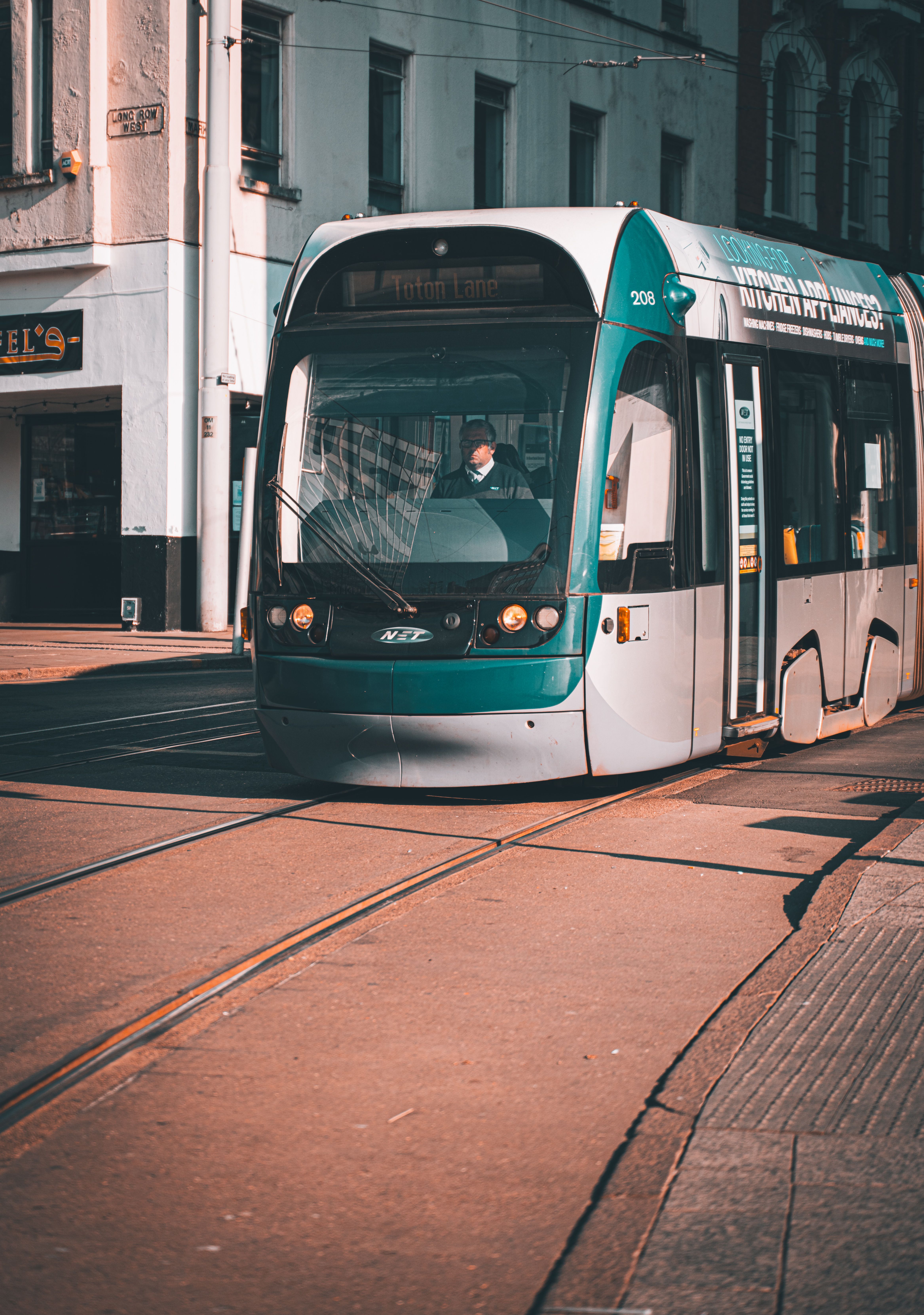 A tram is driving down a street in a city · Free Stock Photo