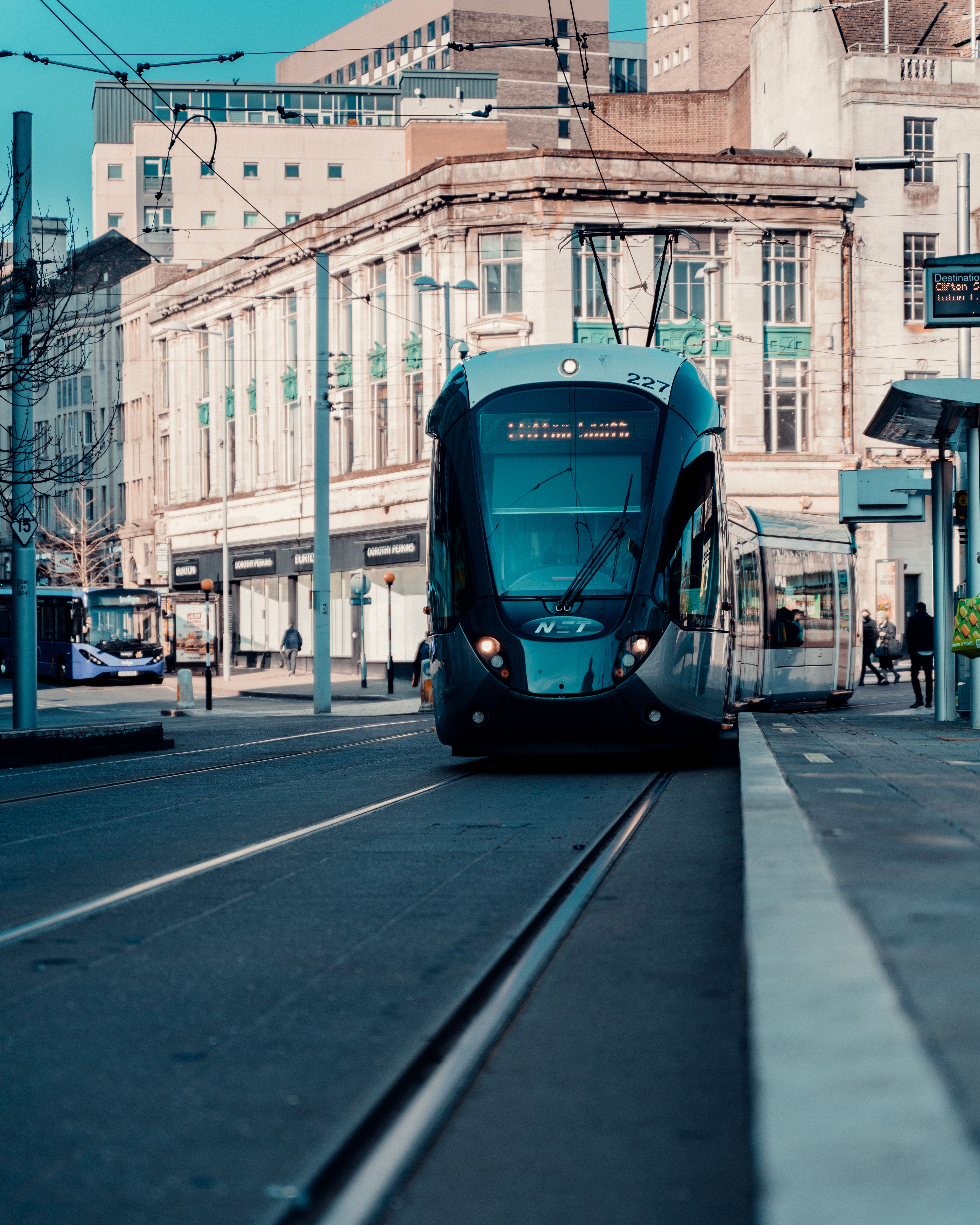 A tram is driving down a street in a city · Free Stock Photo