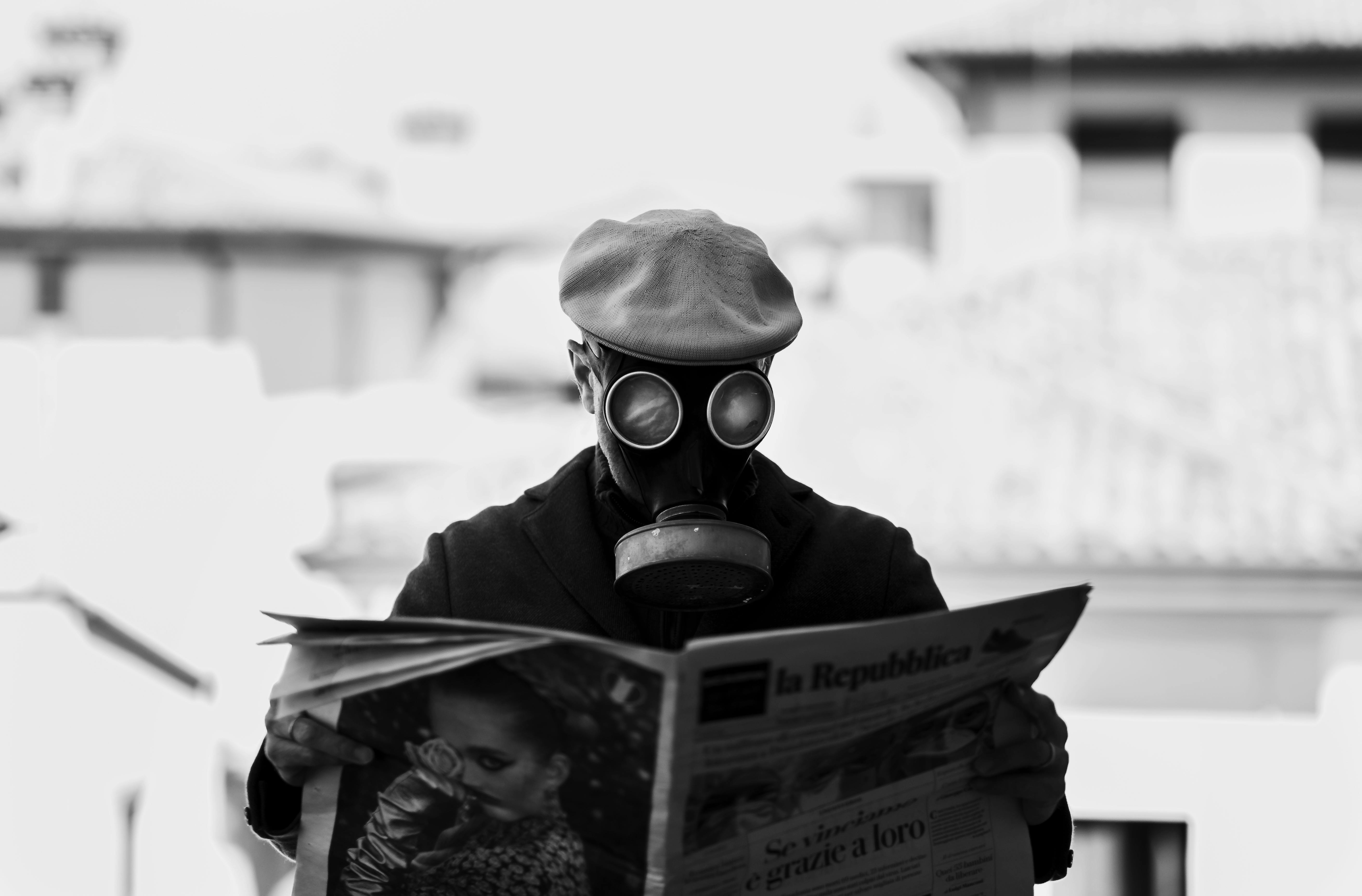 Man in Gas Mask Reading Newspaper · Free Stock Photo