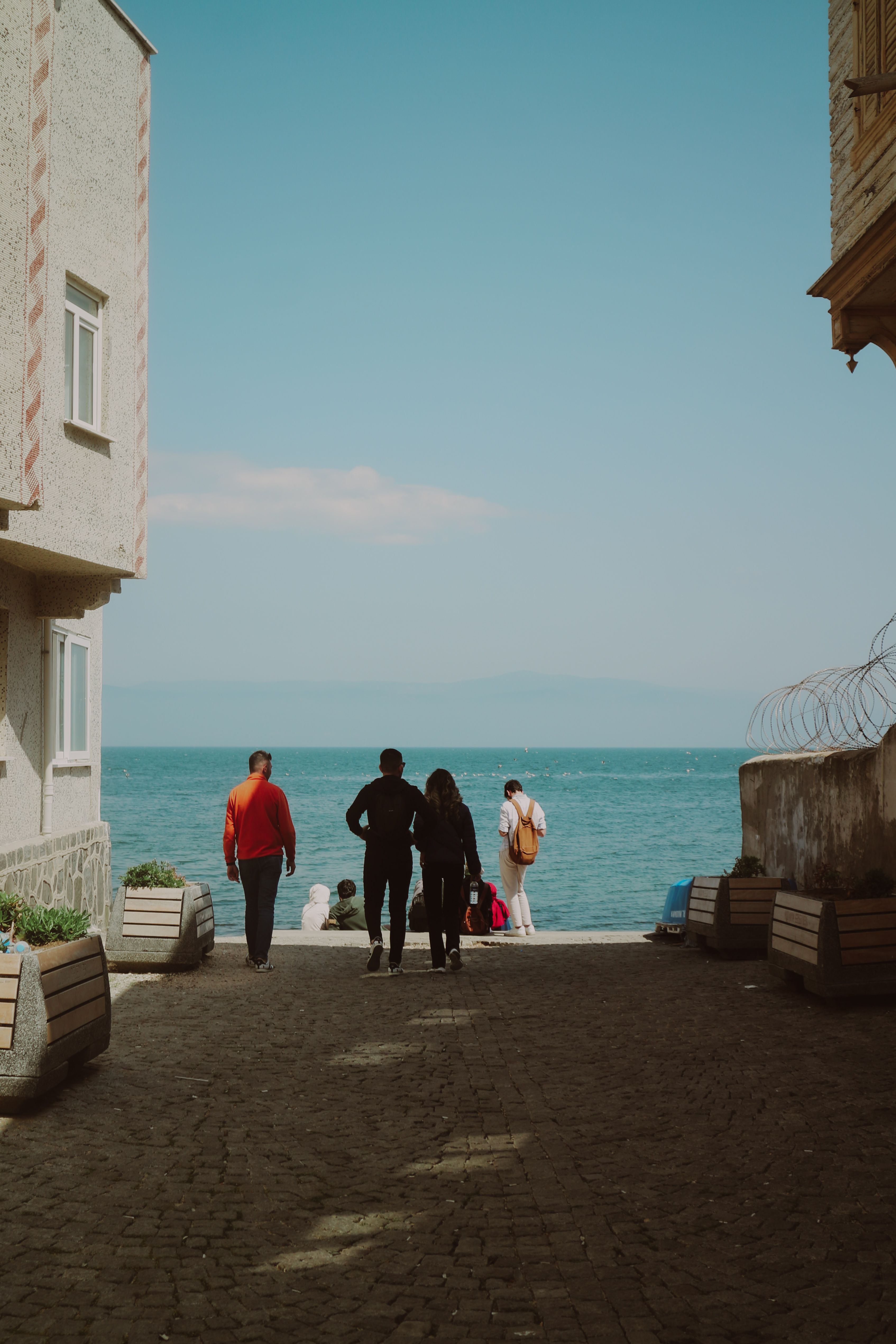 People walking down a street near the ocean · Free Stock Photo
