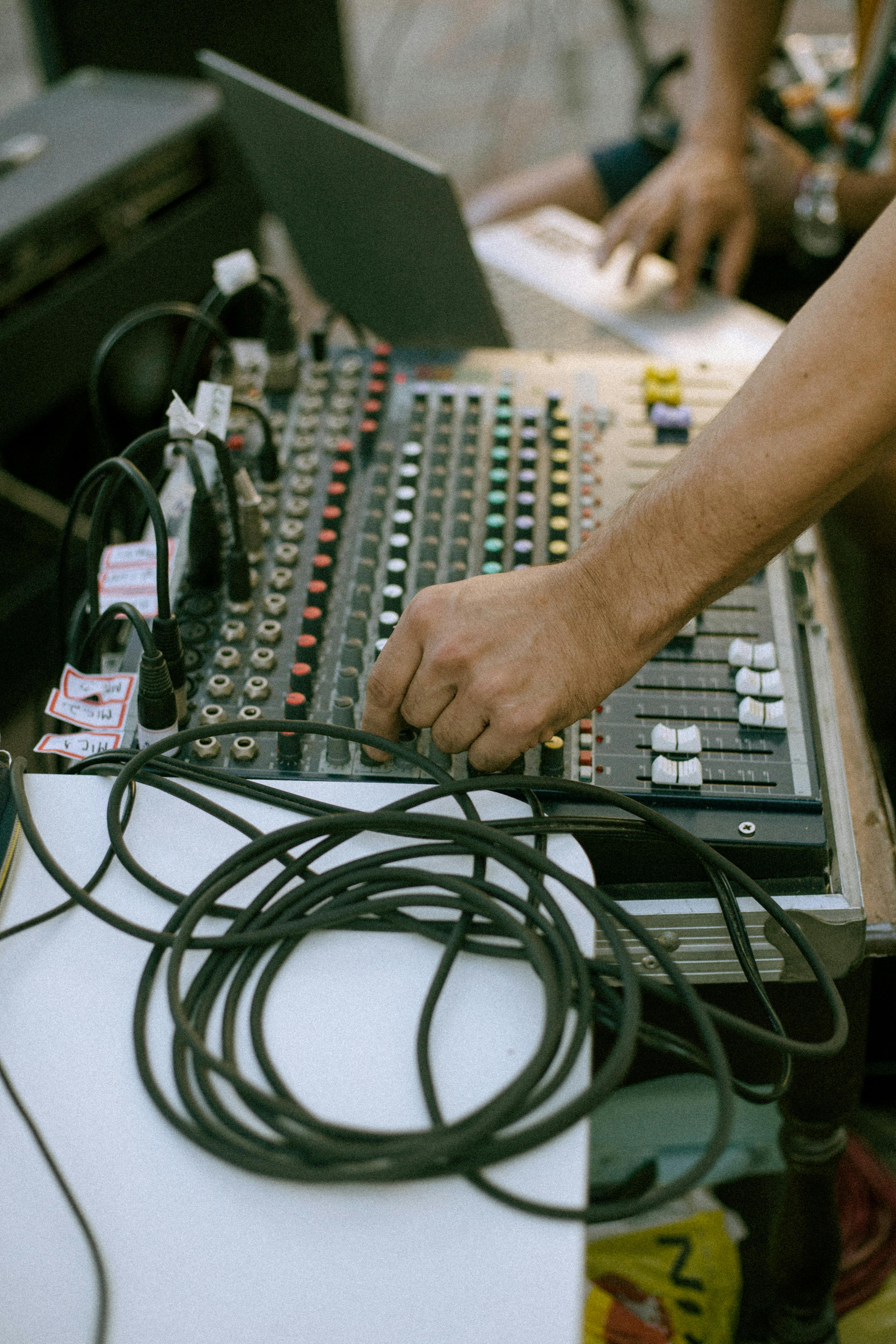A person is using a mixer to mix music · Free Stock Photo