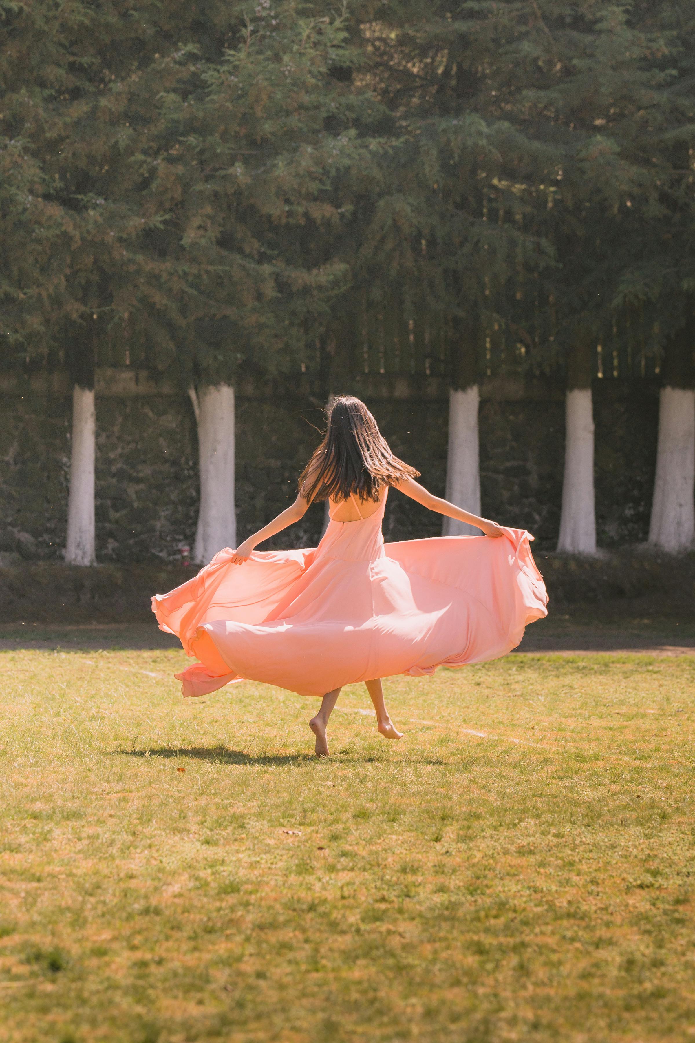 Woman in a Pink Dress Running in a Park · Free Stock Photo