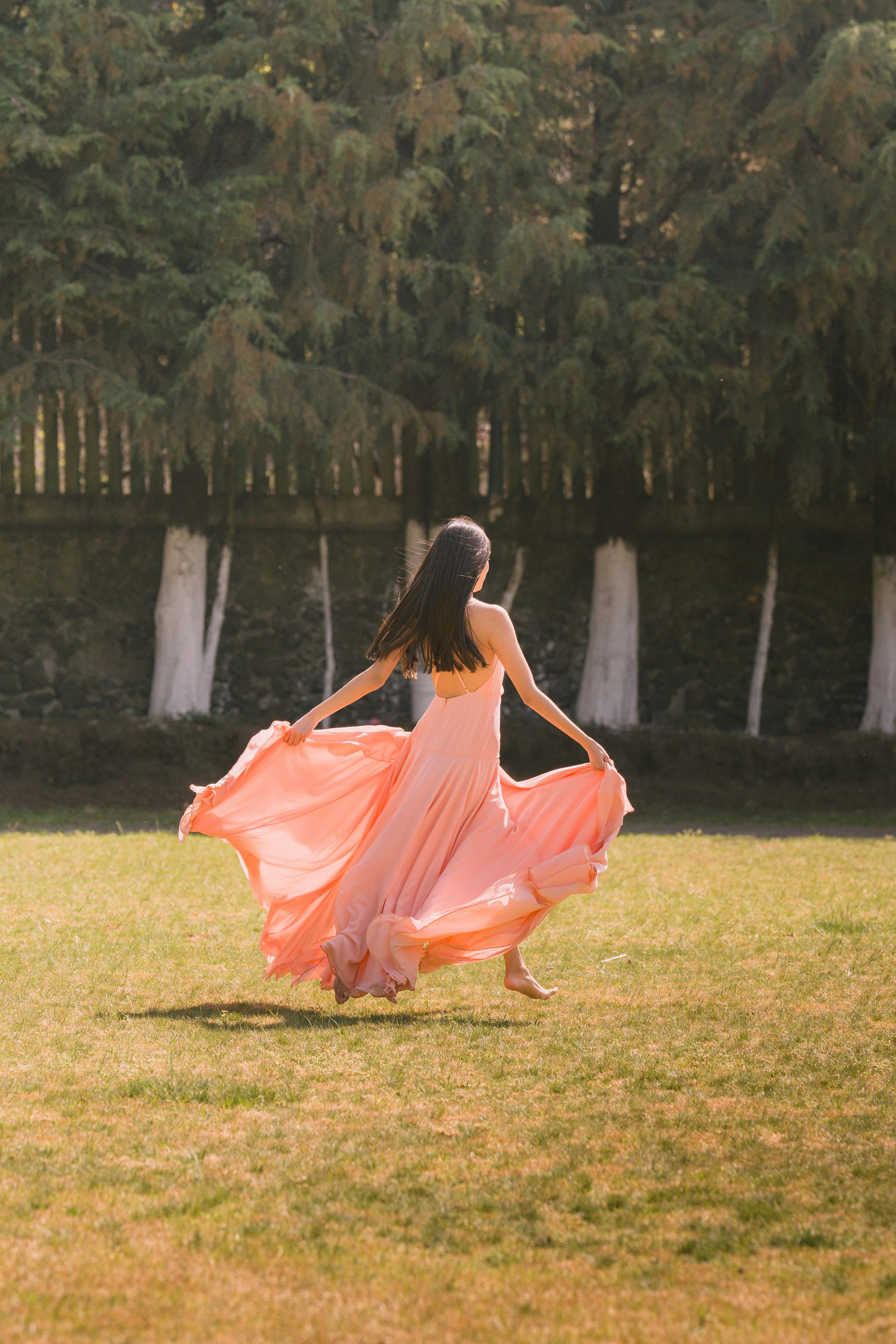 Woman in a Pink Dress Running in a Field · Free Stock Photo