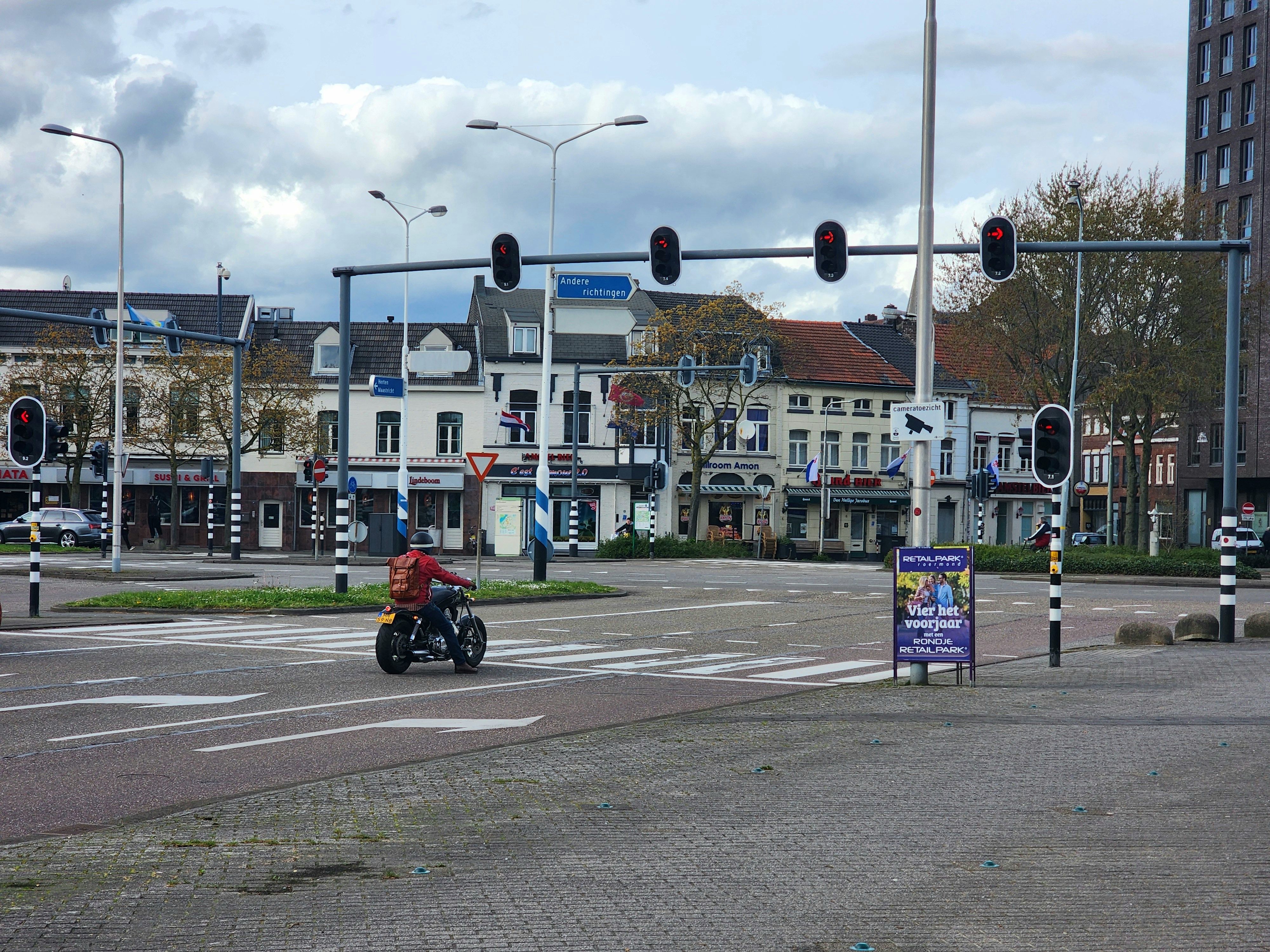A man riding a motorcycle through a city intersection · Free Stock Photo