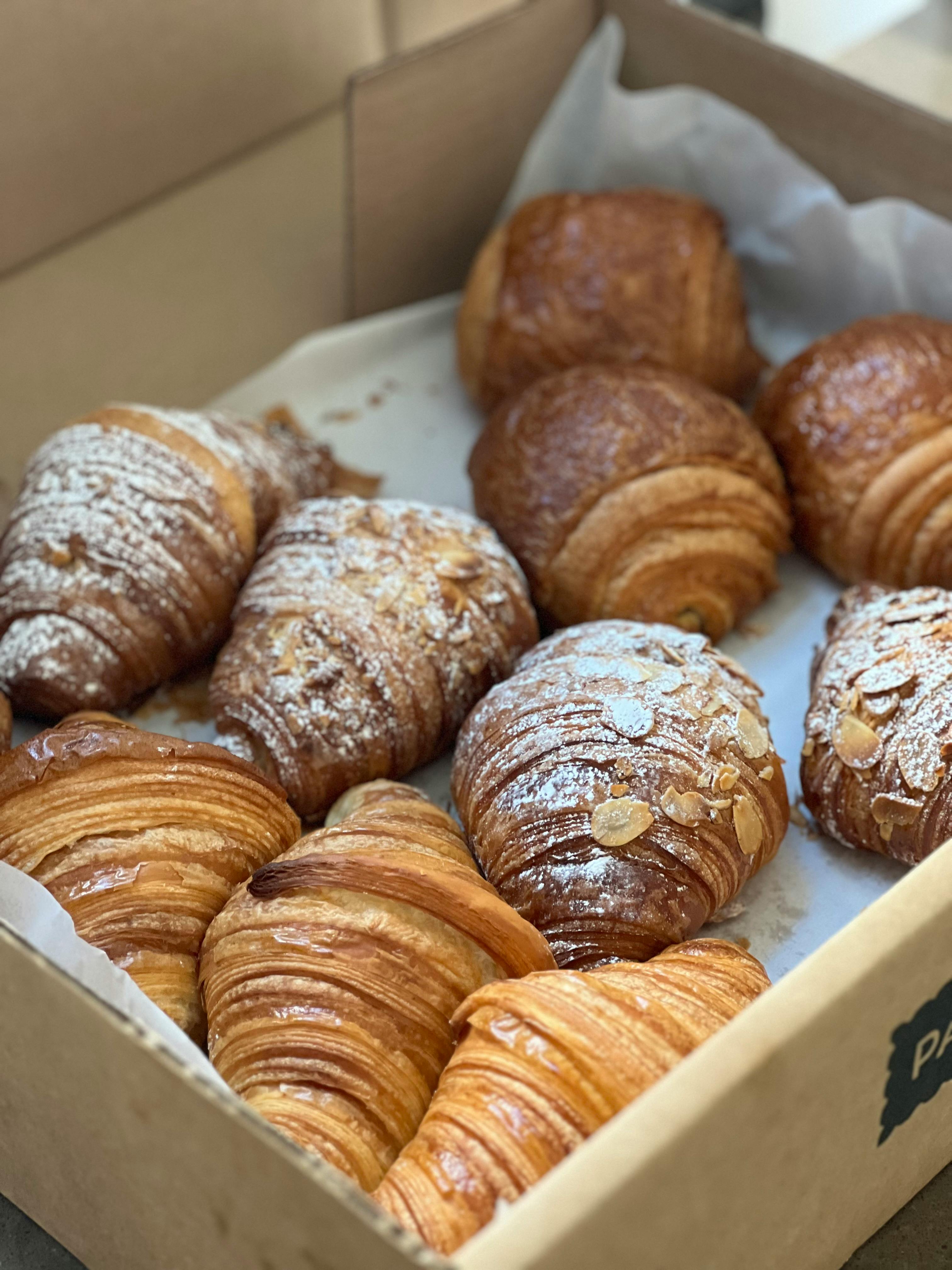 A box of croissants sitting on top of a table · Free Stock Photo