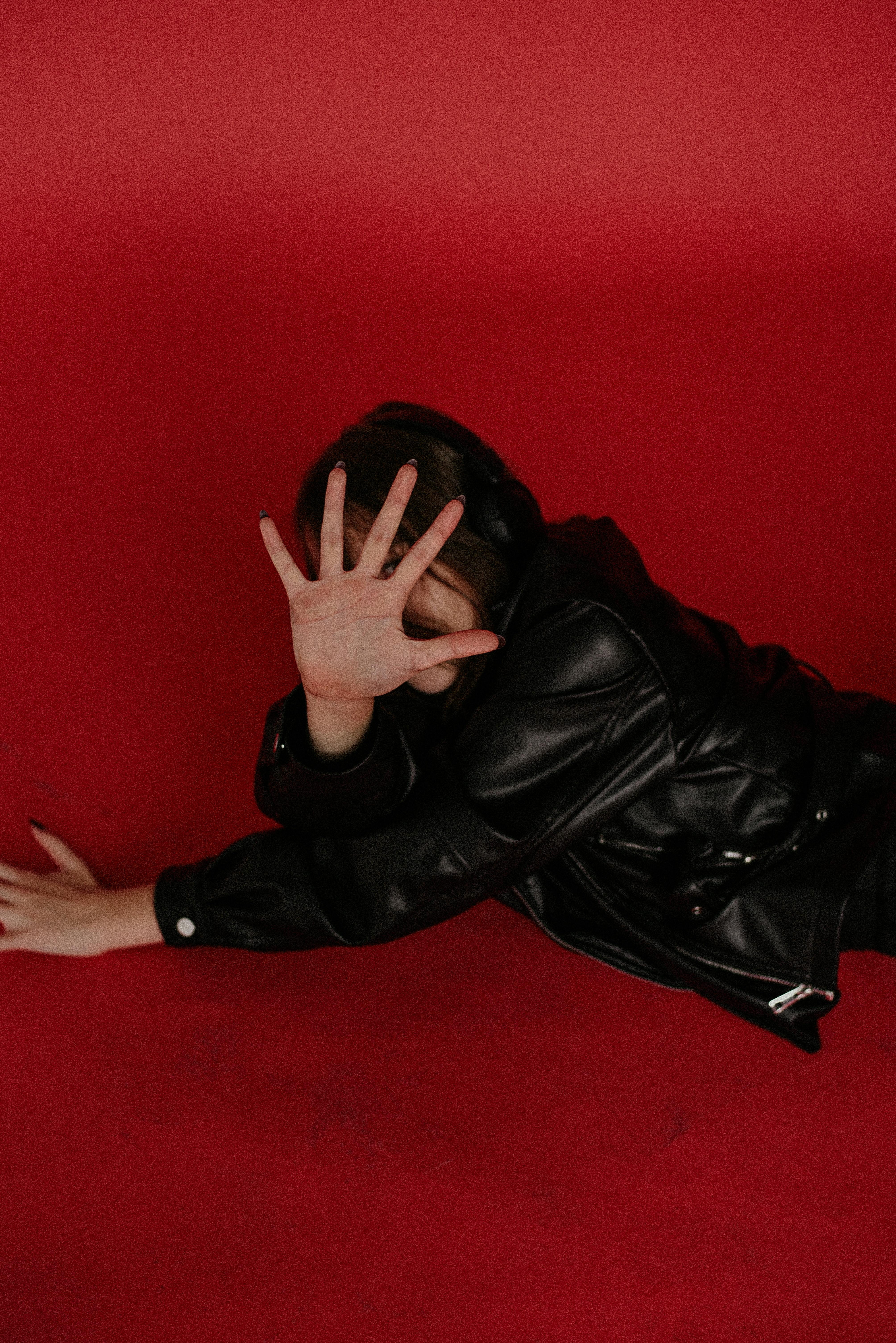 A woman in a black leather jacket laying on her stomach · Free Stock Photo