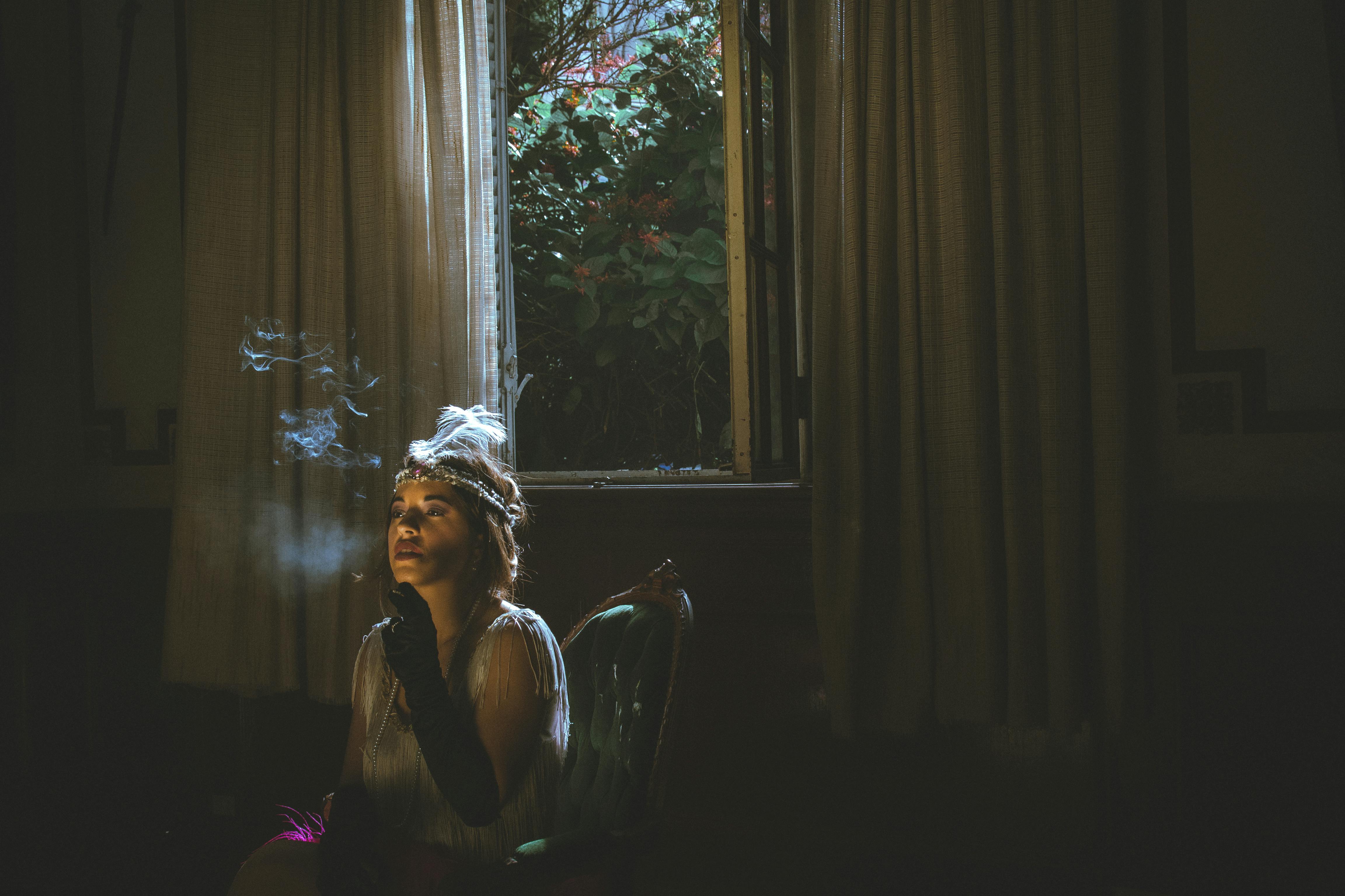 Woman Sitting near Window and Smoking · Free Stock Photo