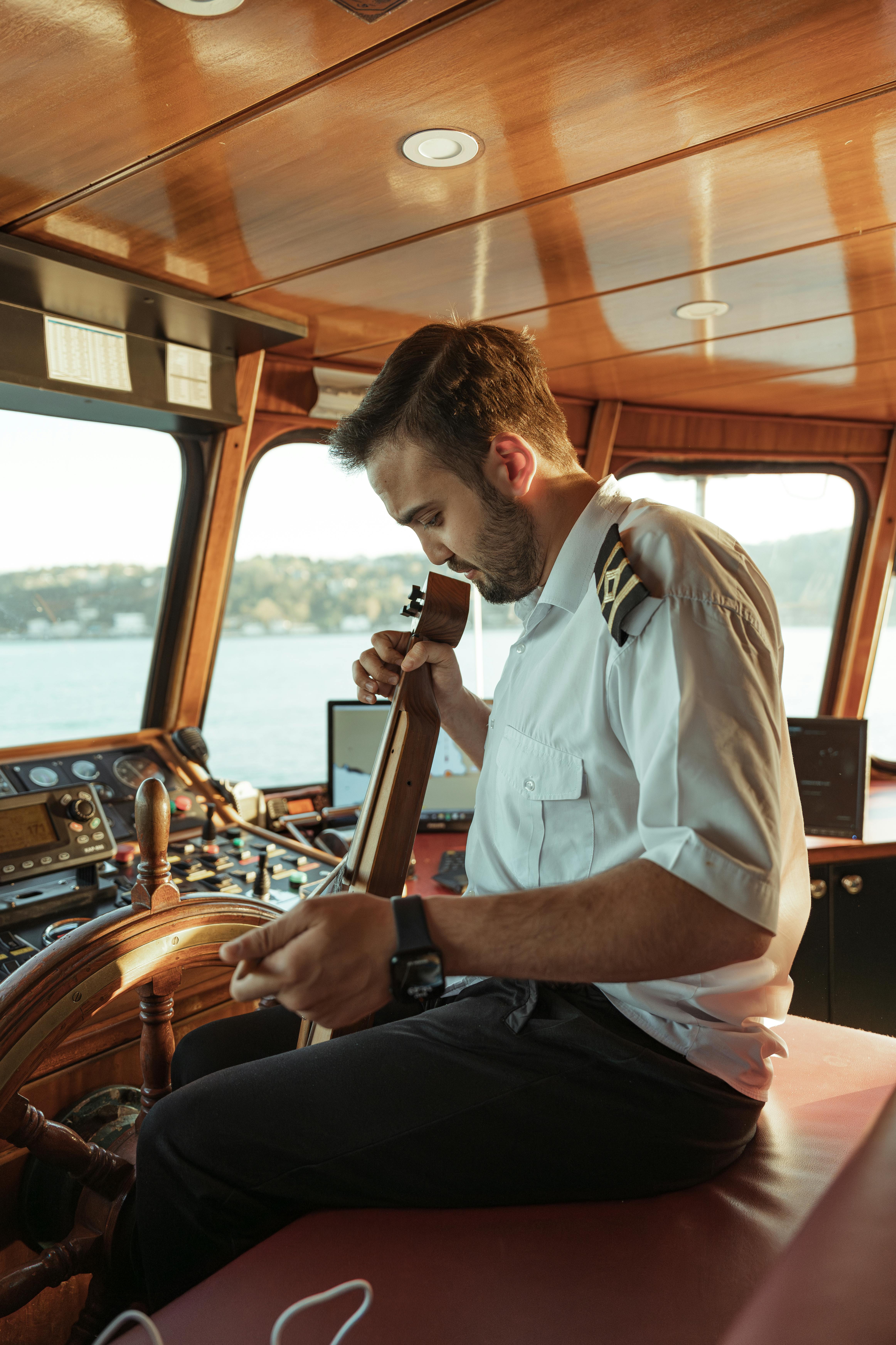 Vessel Captain Sitting with Musical Instrument · Free Stock Photo