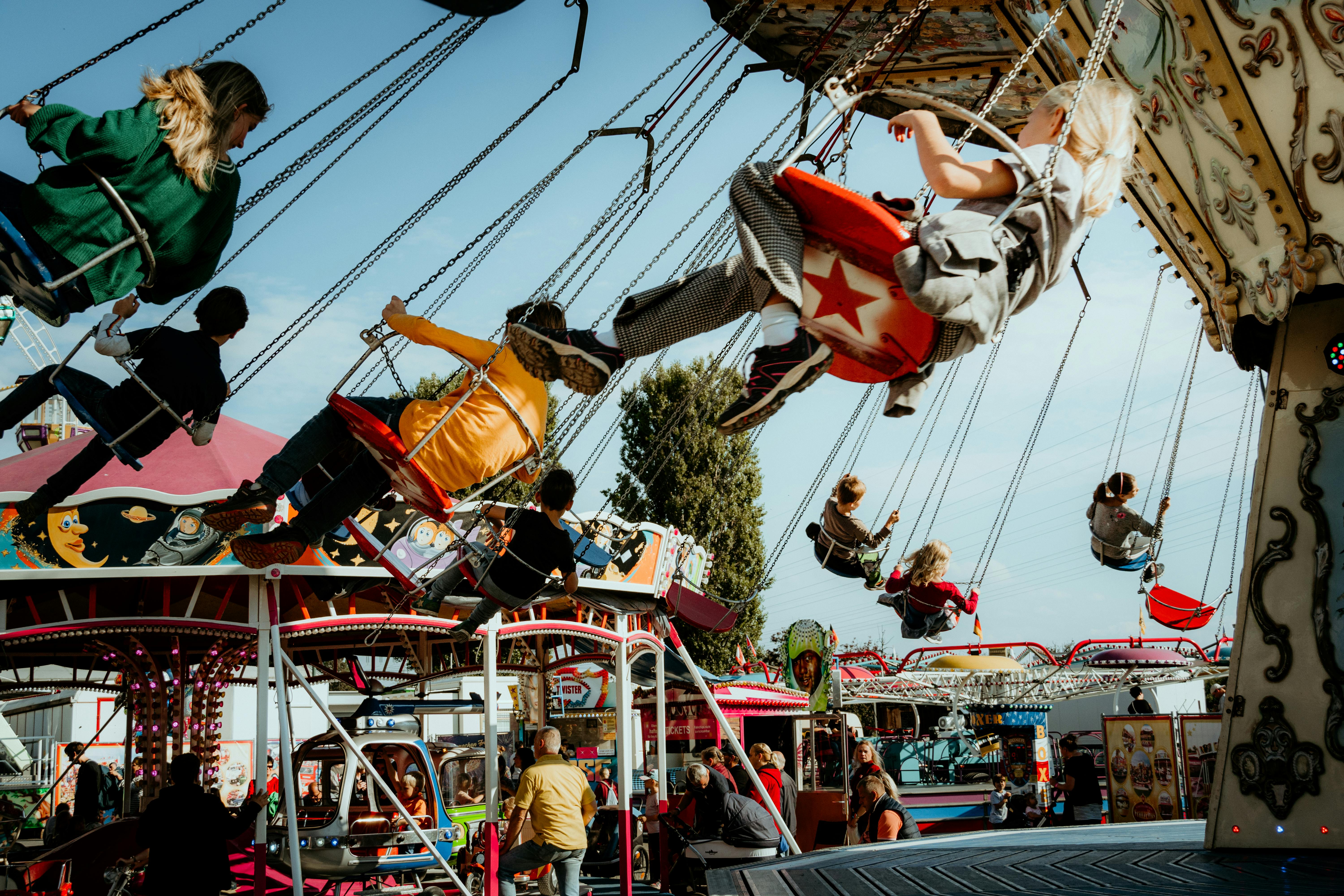 A group of people riding on a carousel at a fair · Free Stock Photo